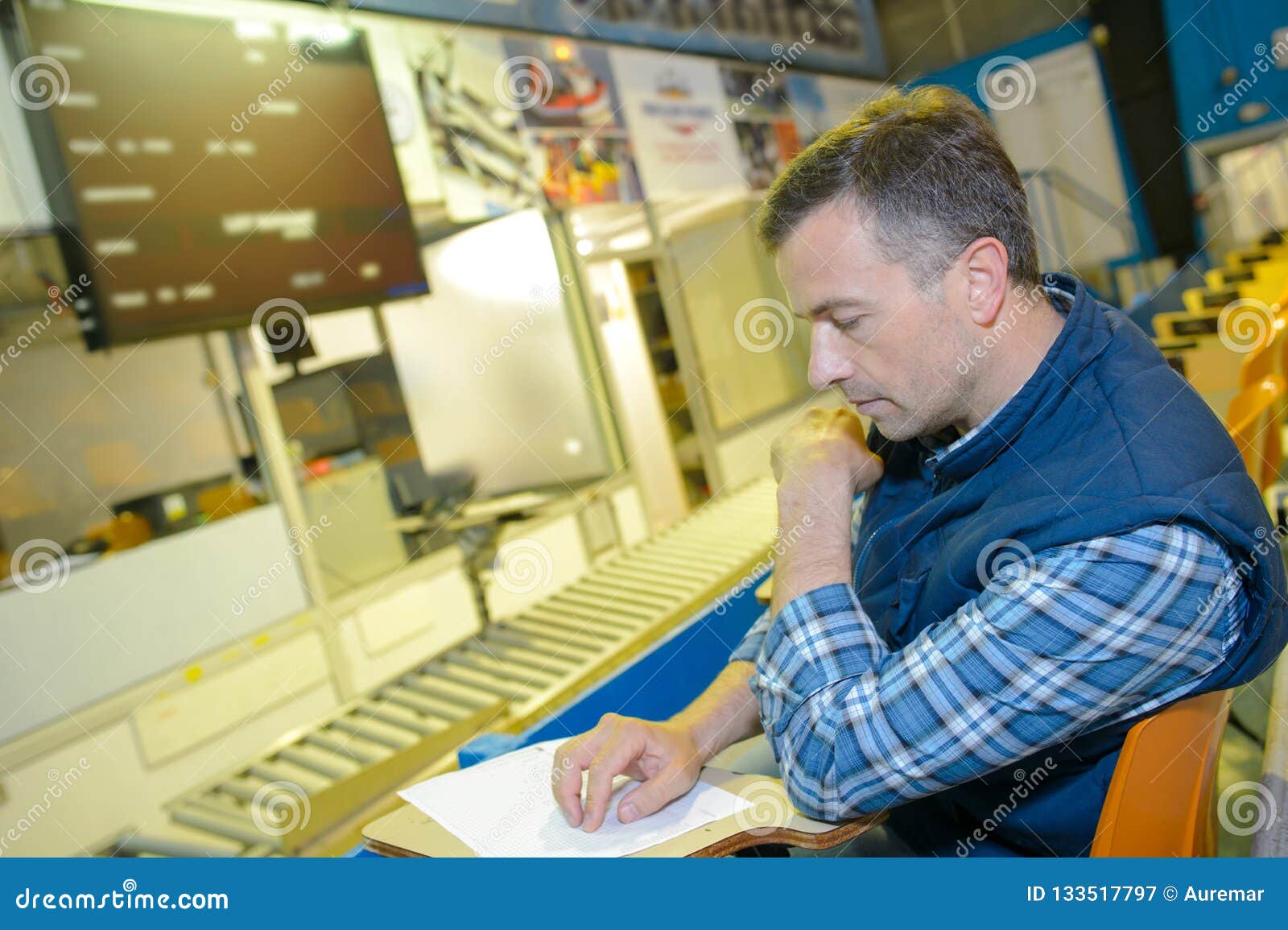 Man in Auditorium Looking at Paperwork Stock Image - Image of auction ...
