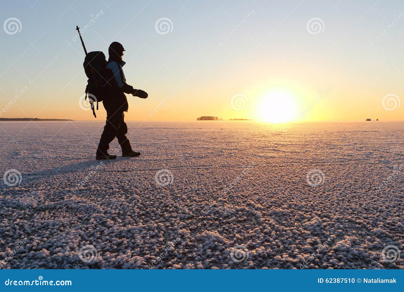 The Man with a Backpack Going on Ice on the River at Sunset Stock Photo ...