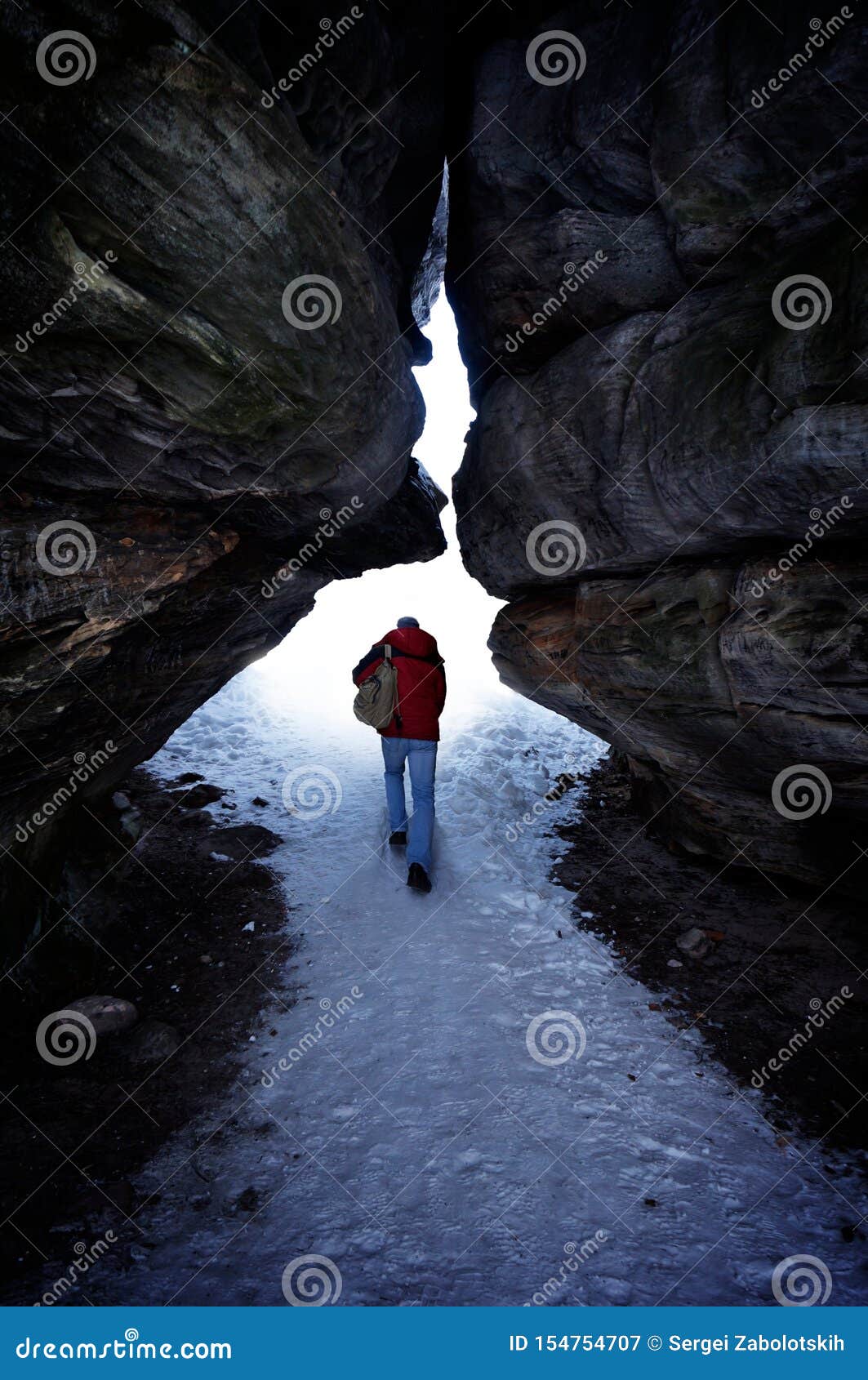 A Man with a Backpack Out of the Dark Snow-cavern in the Bright Light ...