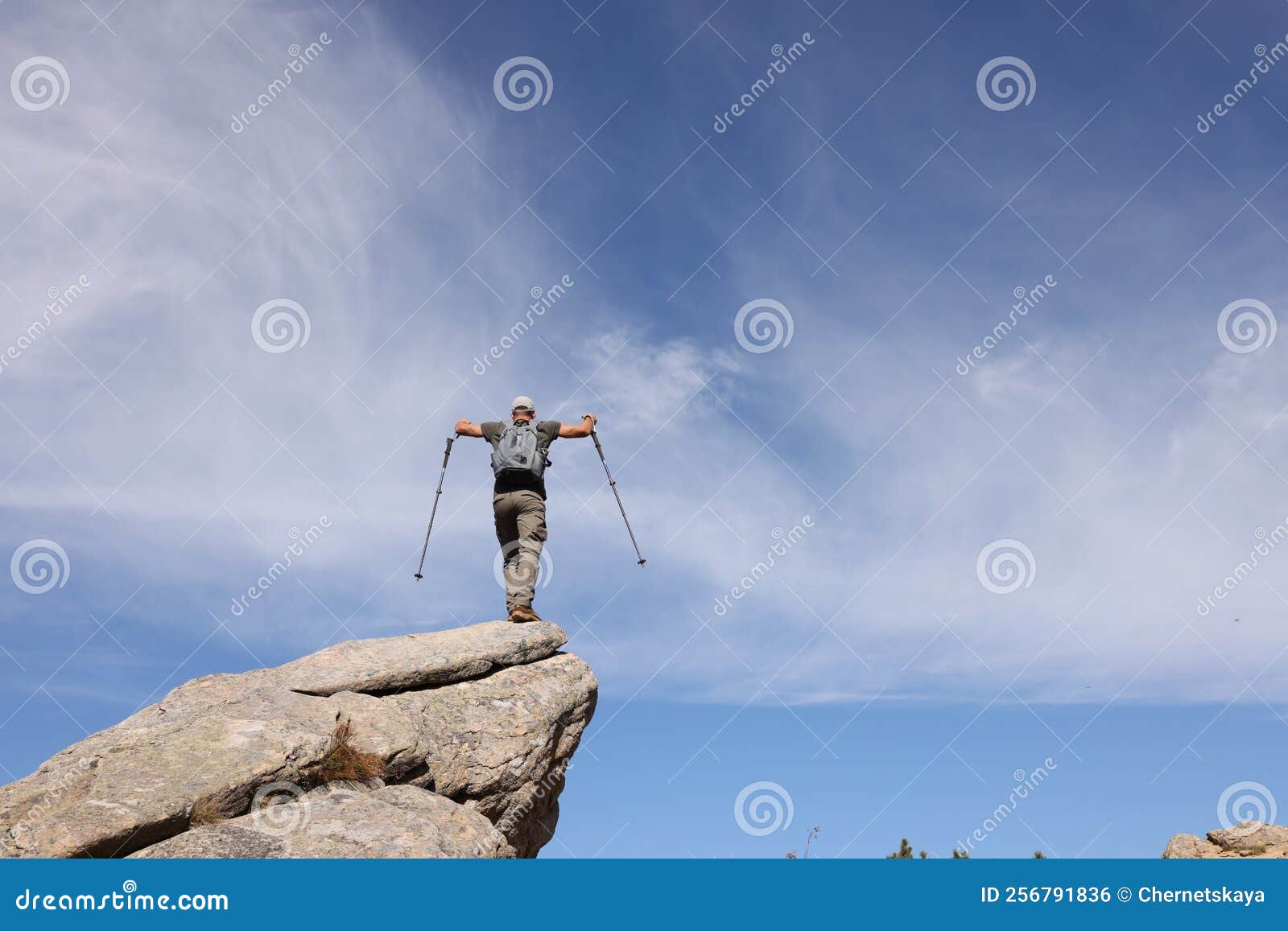 Man with Backpack and Trekking Poles on Rocky Peak in Mountains, Back ...