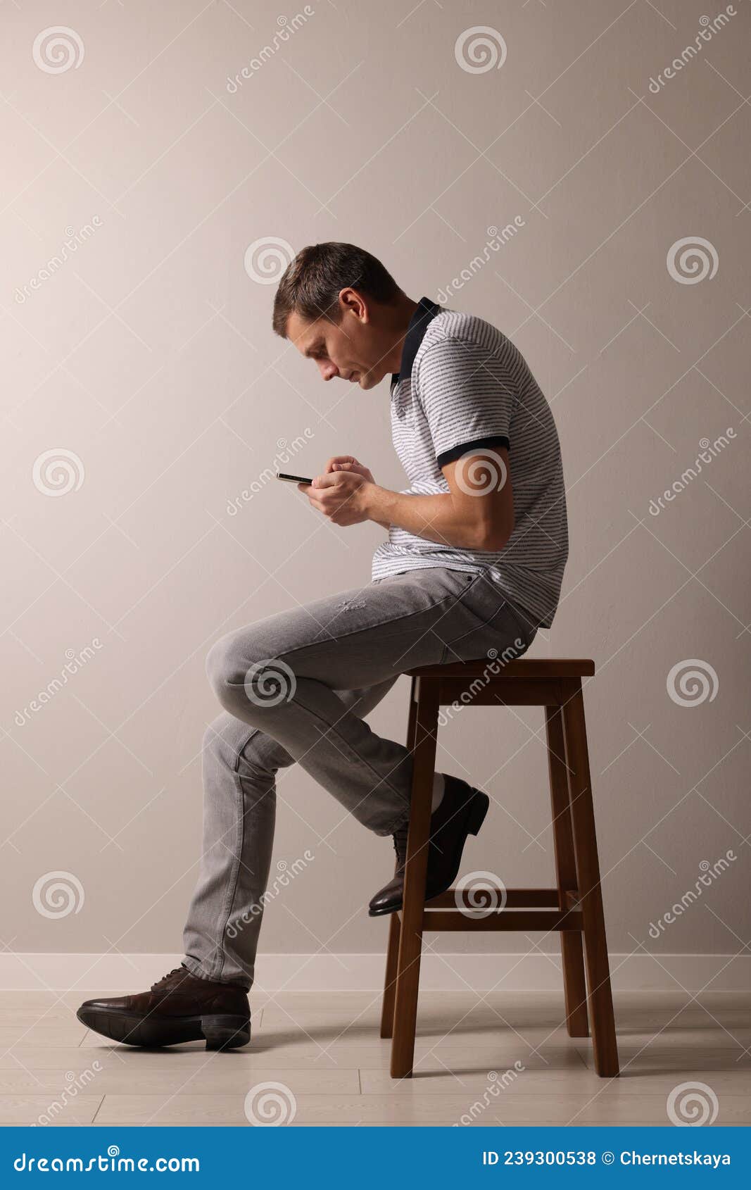 Man with Bad Posture Using Smartphone while Sitting on Stool Against ...