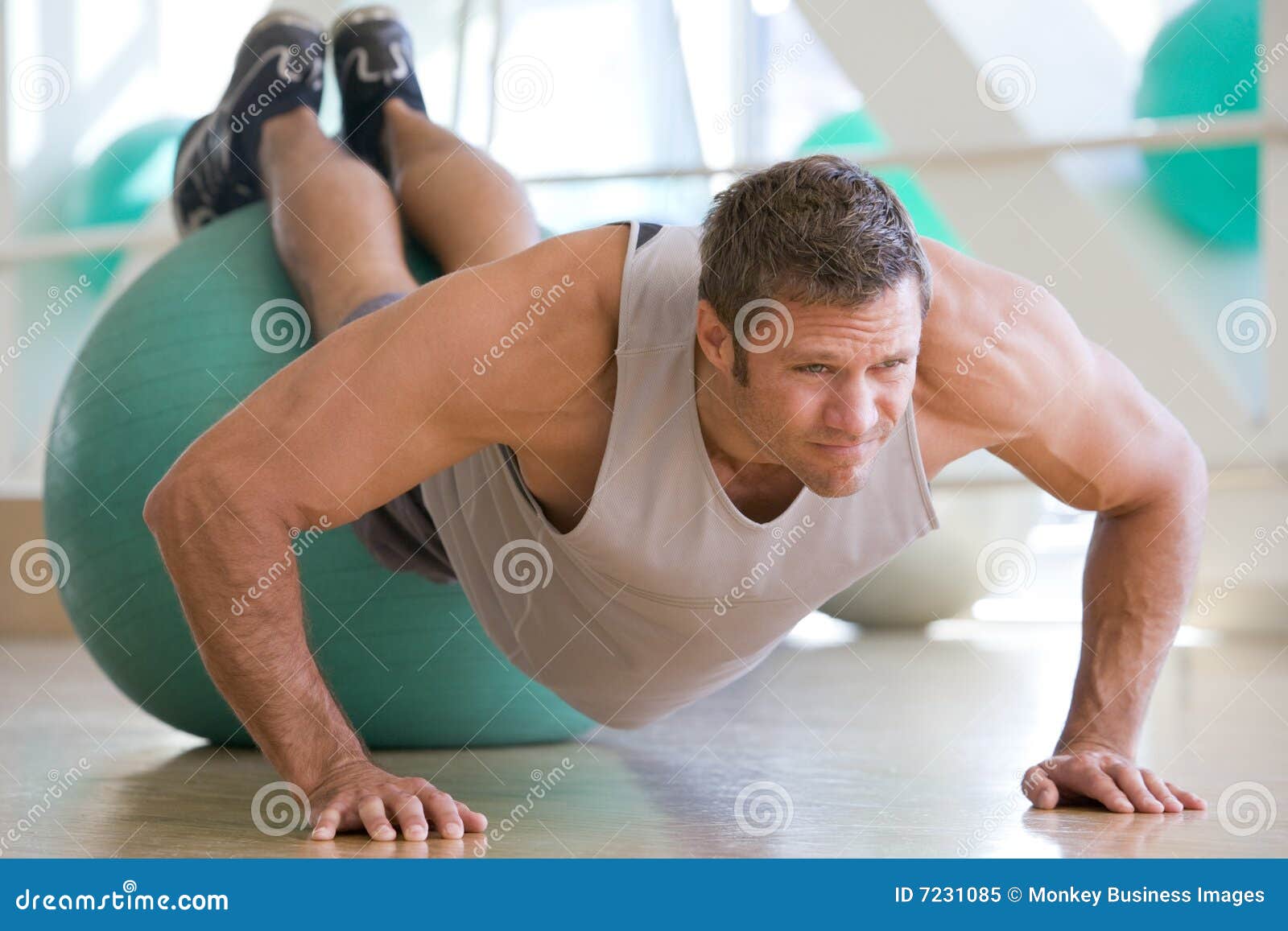 Man Balancing on Swiss Ball at Gym Stock Image - Image of inflatable ...