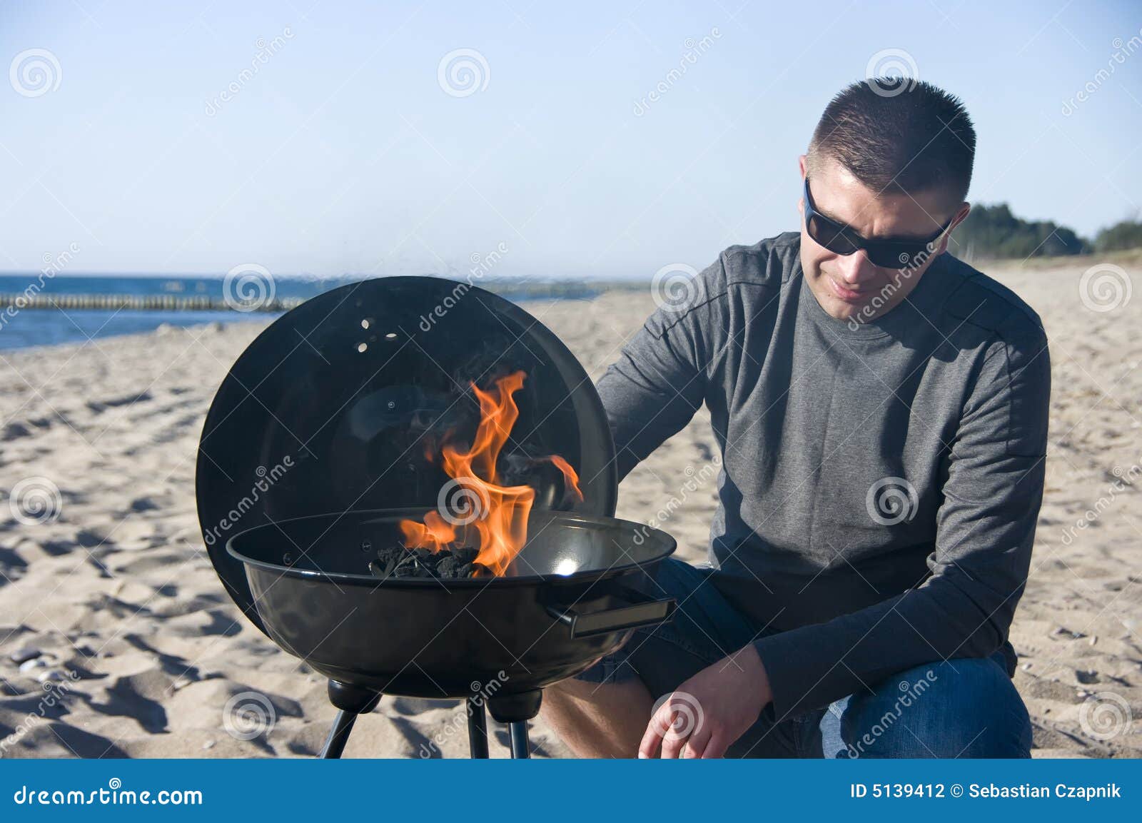 Man and barbecue on beach stock photo. Image of sunglasses - 5139412