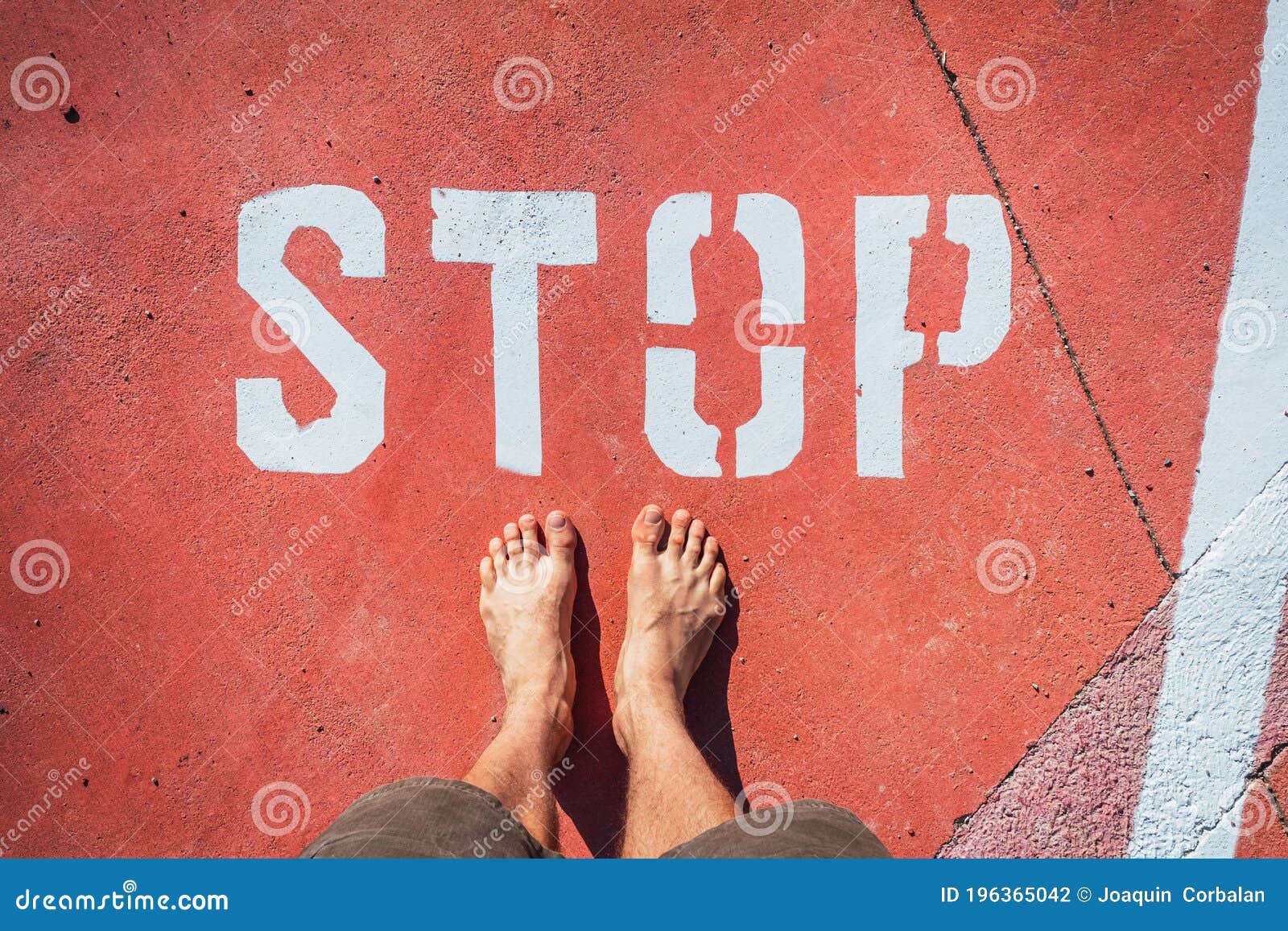 A Man in Bare Feet Stops at a Stop Mark Painted on the Ground Stock ...