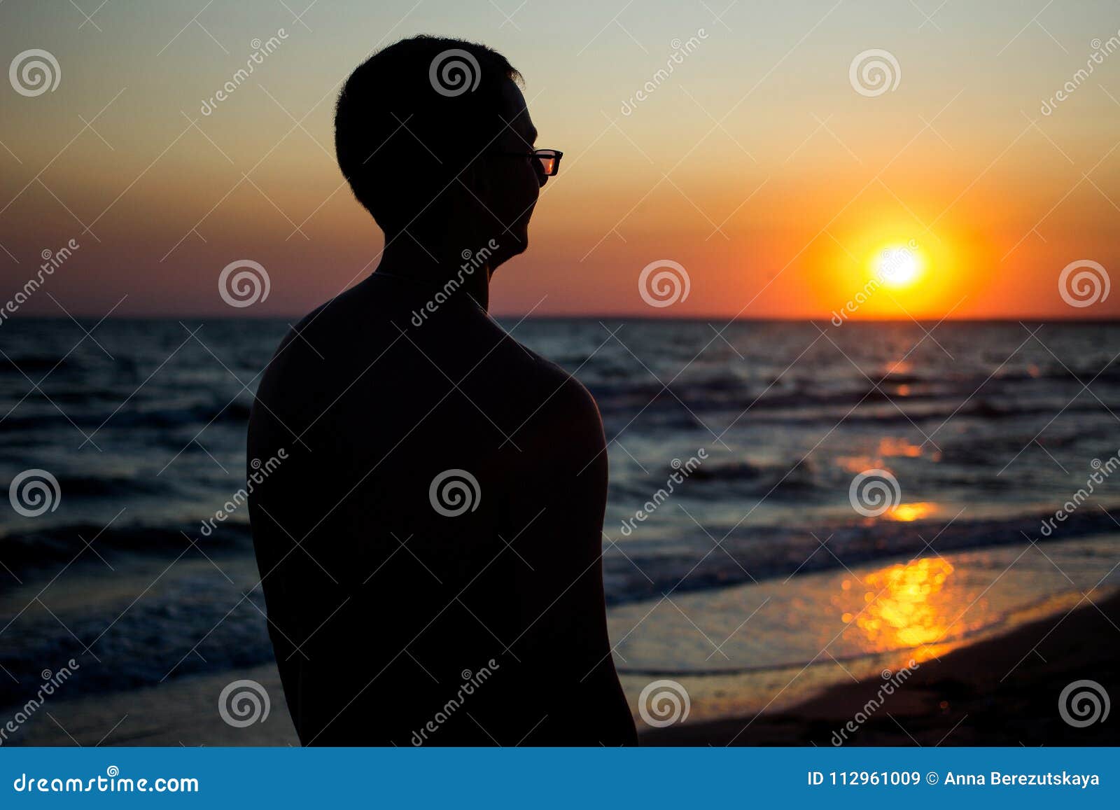 Young Man Silhouette Facing a Beautiful Sunset at the Beach Stock Image ...