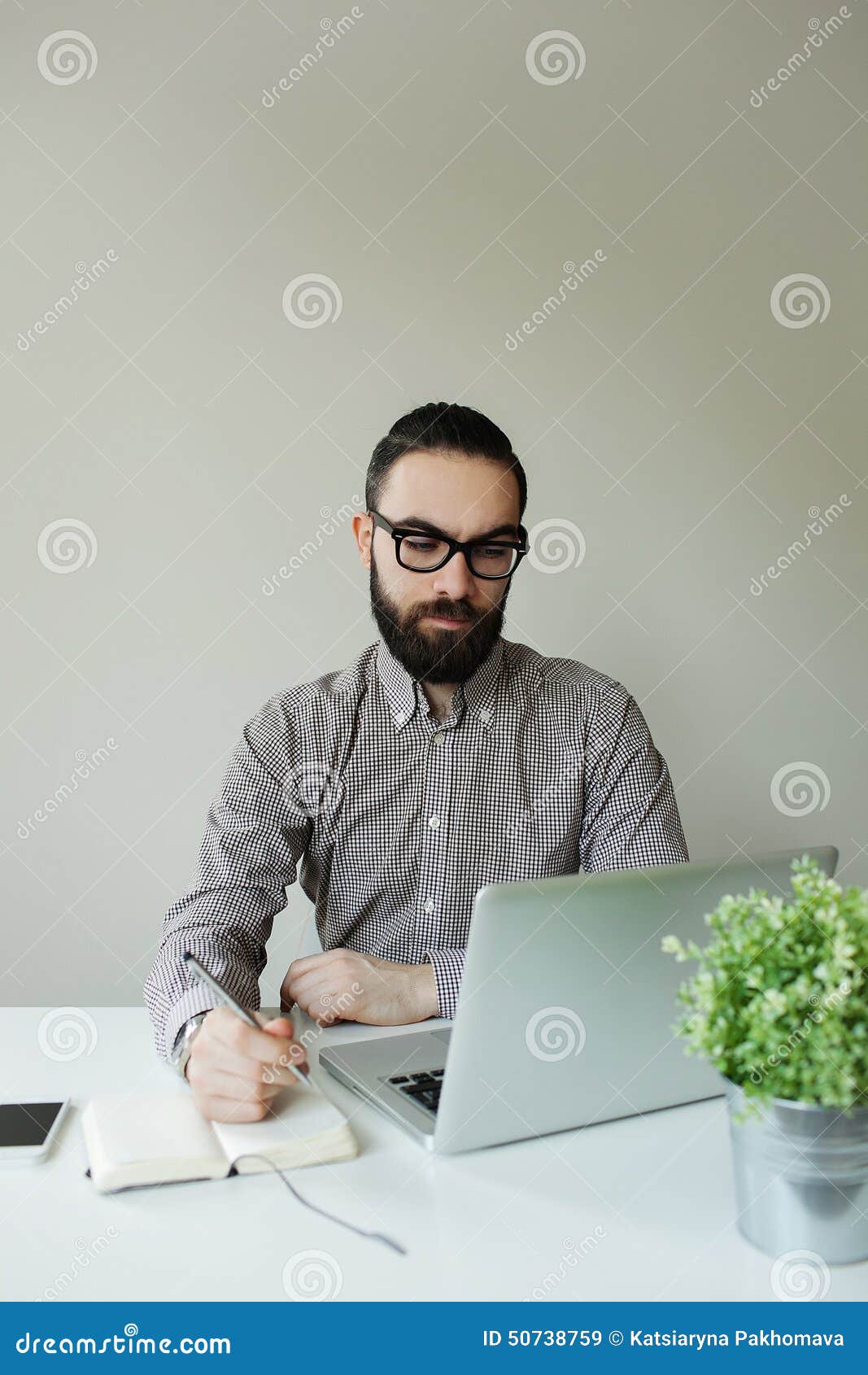 Man with Beard in Glasses Taking Notes with Laptop and Notepad Stock ...