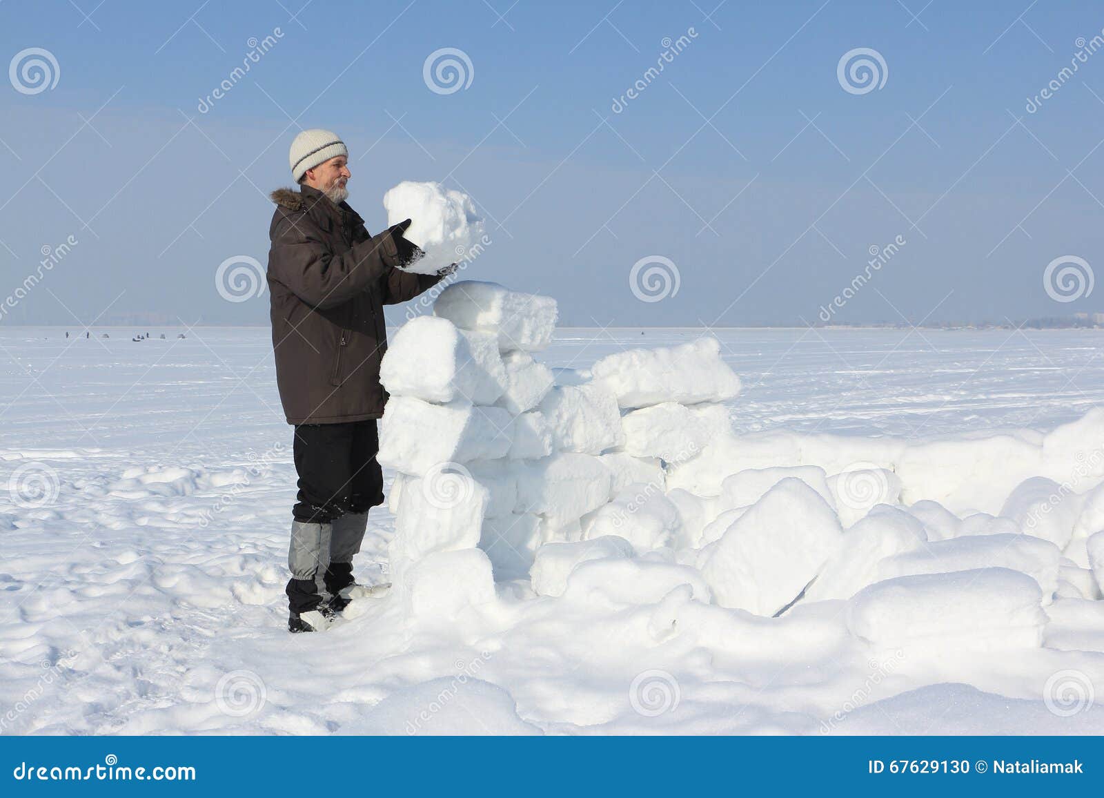 The Man with a Beard in a Gray Cap Building an Igloo Stock Photo ...
