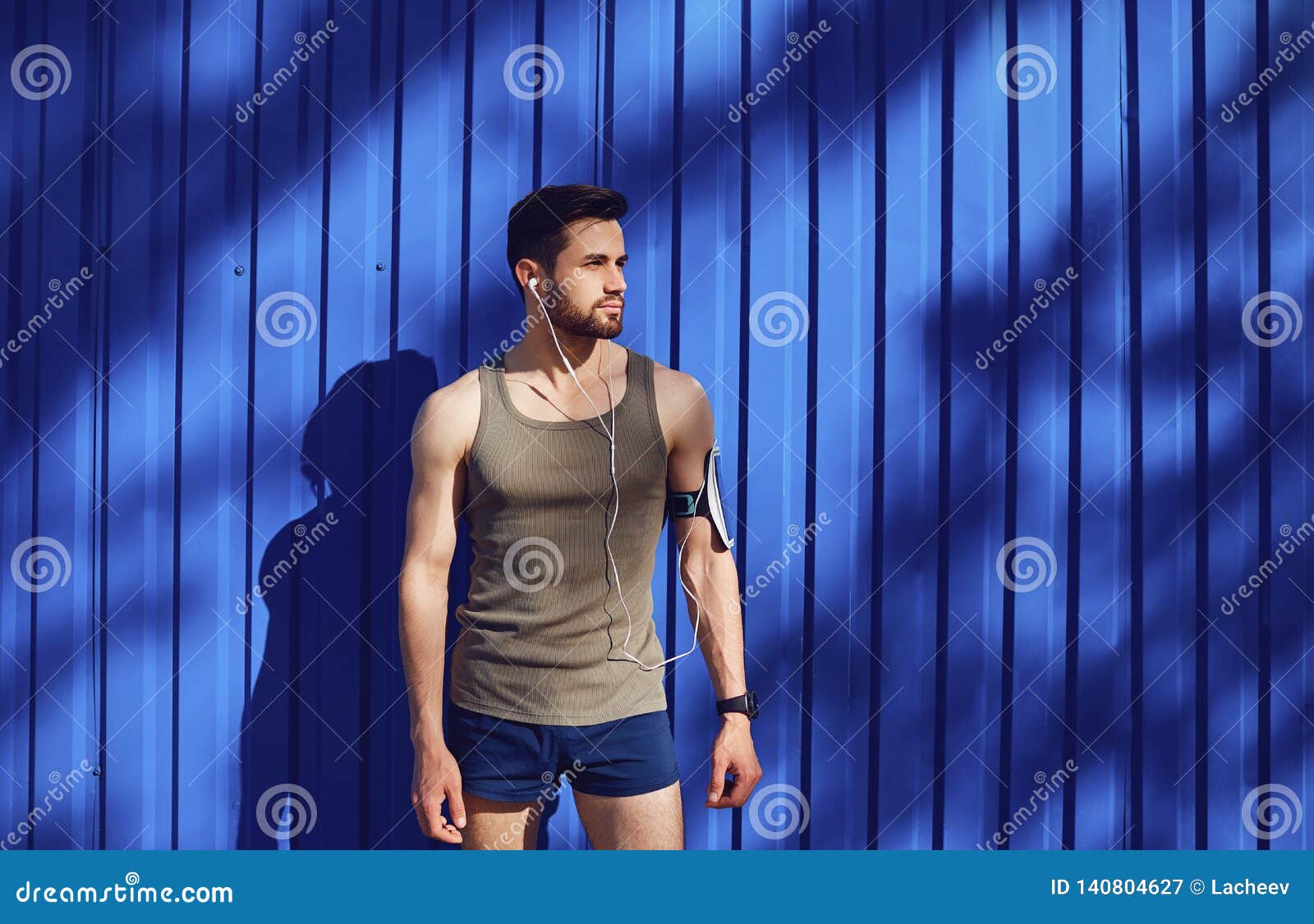 A Man with a Beard Runner Against a Blue Wall Background. Stock Image ...