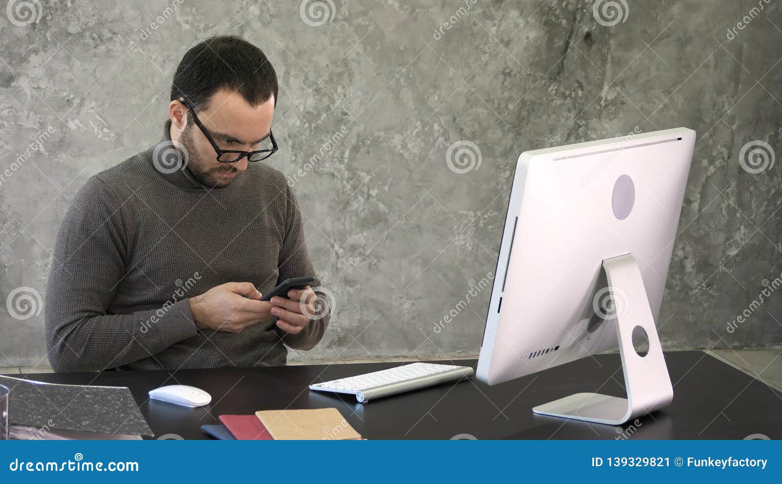 Man with Beard, he is Sitting at a Black Table, Looking at His ...
