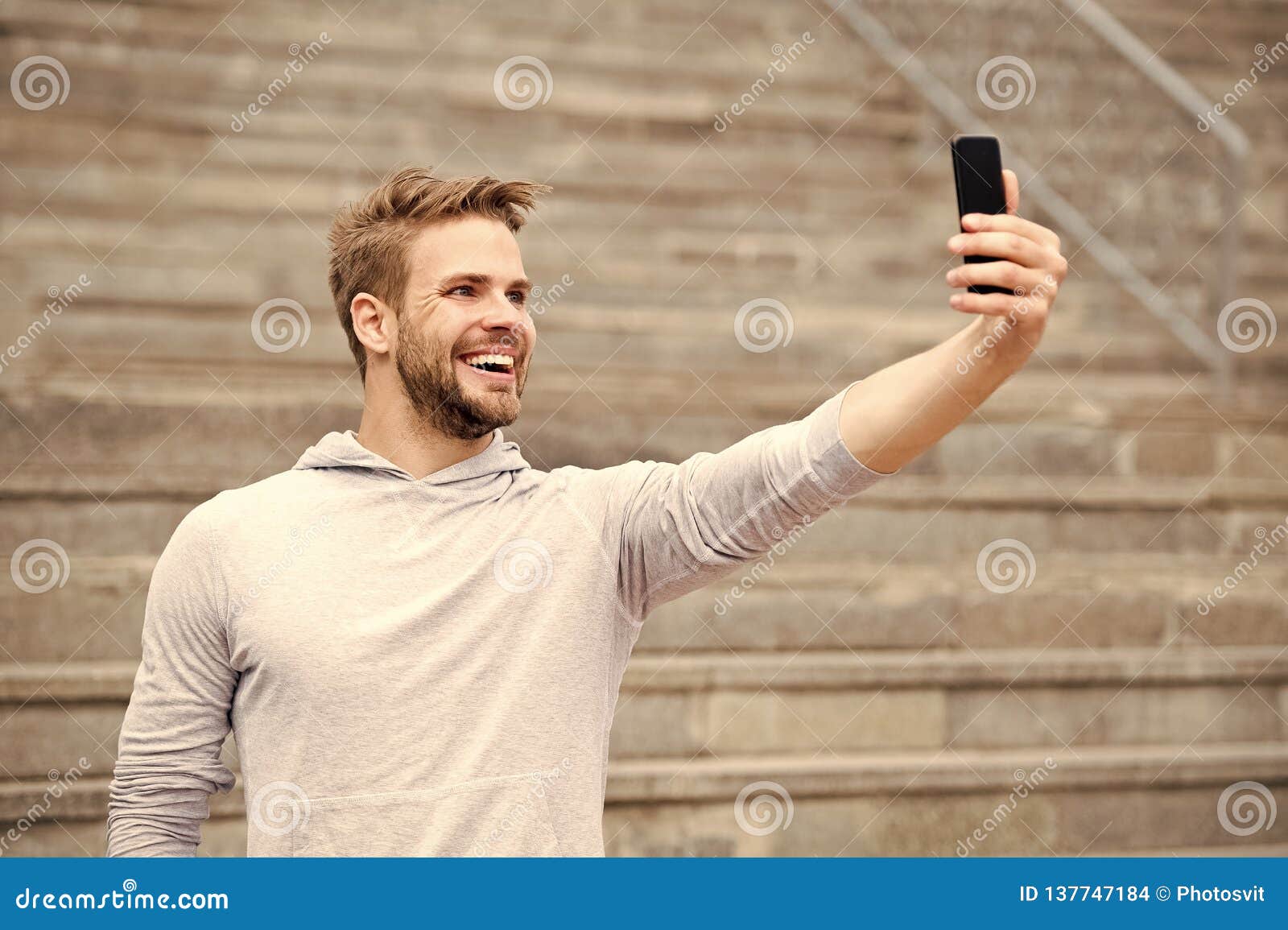 Man With Beard Walks With Smartphone Urban Background With Stairs Man