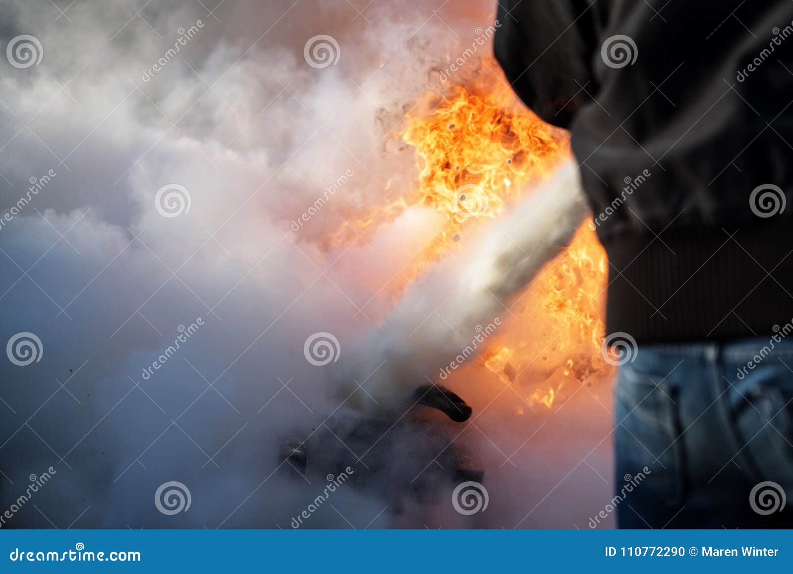 Man from Behind is Fighting a Fire with Foam from a Fire Extinguisher ...