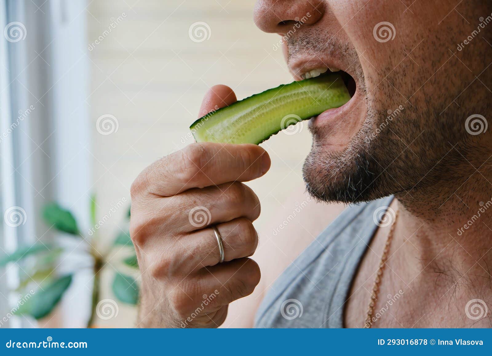 A man bites a cucumber. stock photo. Image of vegetable - 293016878