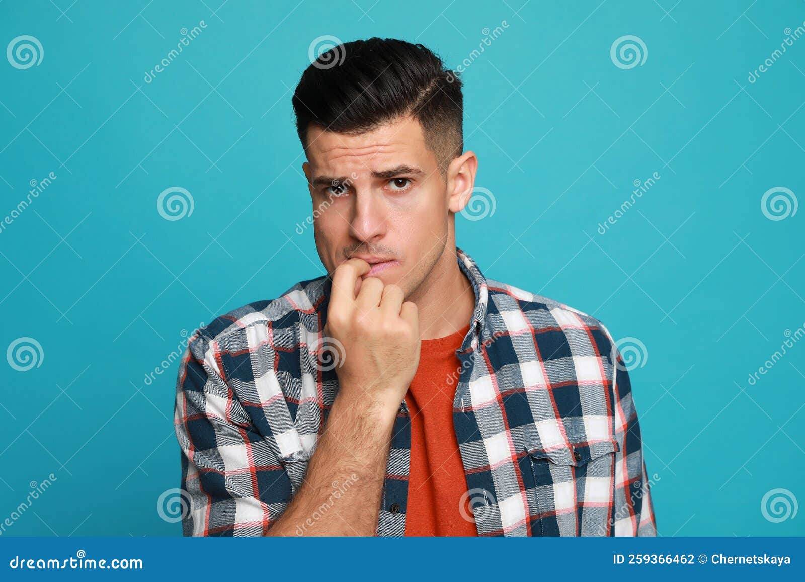 Man Biting His Nails on Light Blue Background. Bad Habit Stock Photo ...
