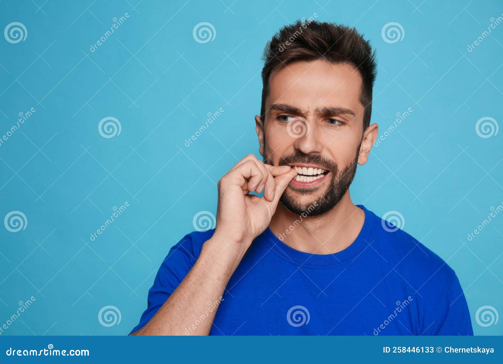 Man Biting His Nails on Light Blue Background. Space for Text Stock ...