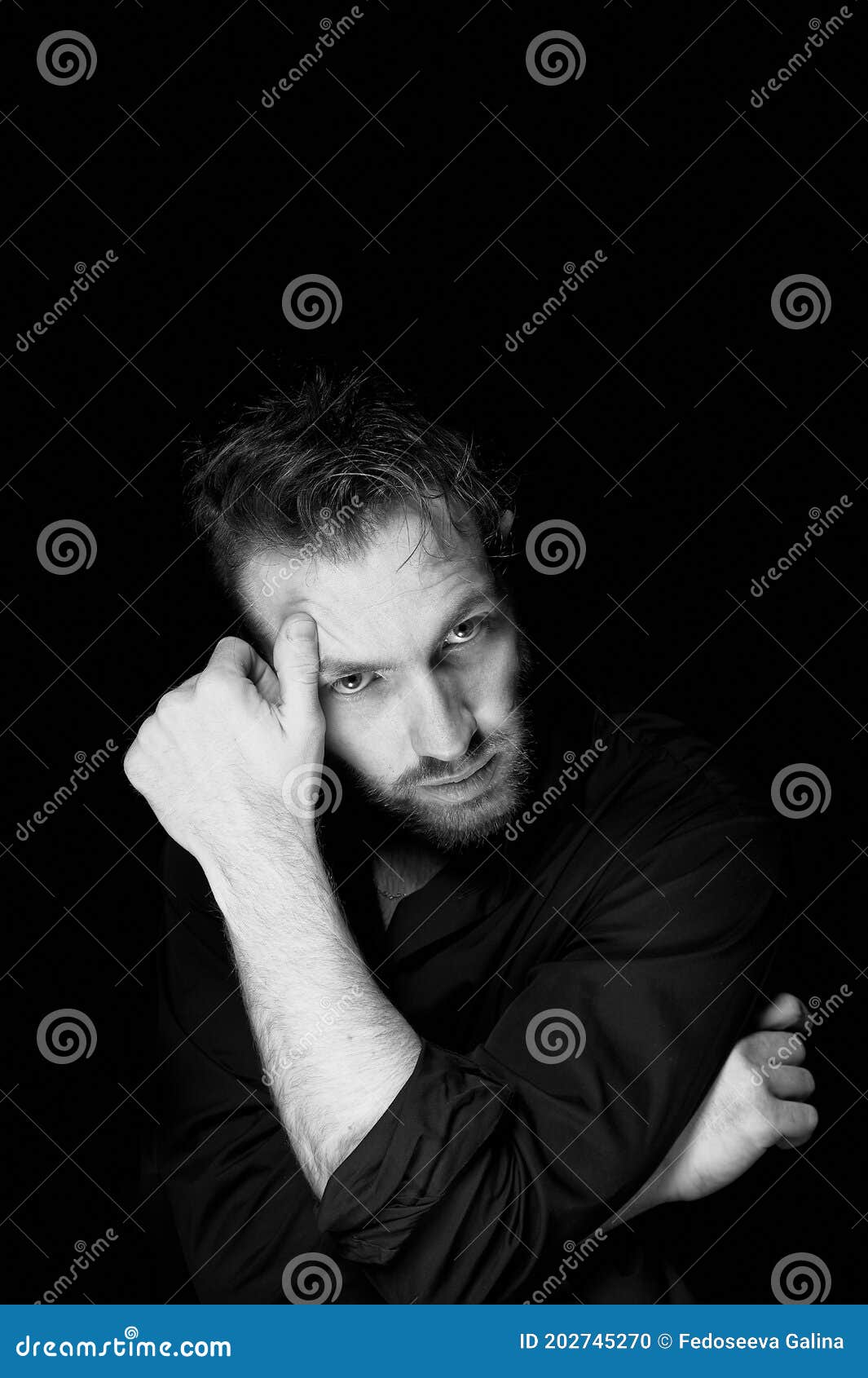 A Man on a Black Background. he Looks Thoughtfully into the Frame. a ...