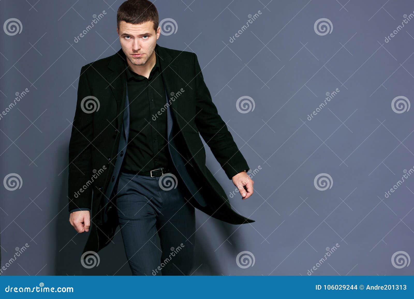 Man in a Black Coat on a Gray Background Studio Stock Photo - Image of ...