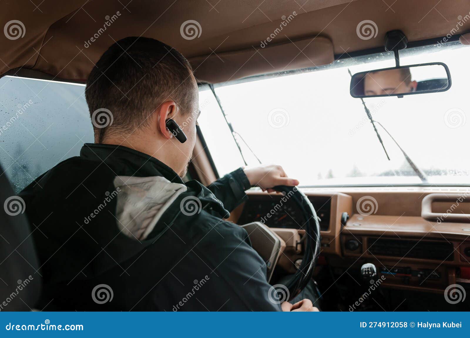 A Man in a Black Jacket Driving a Car in the Mountains Stock Photo ...
