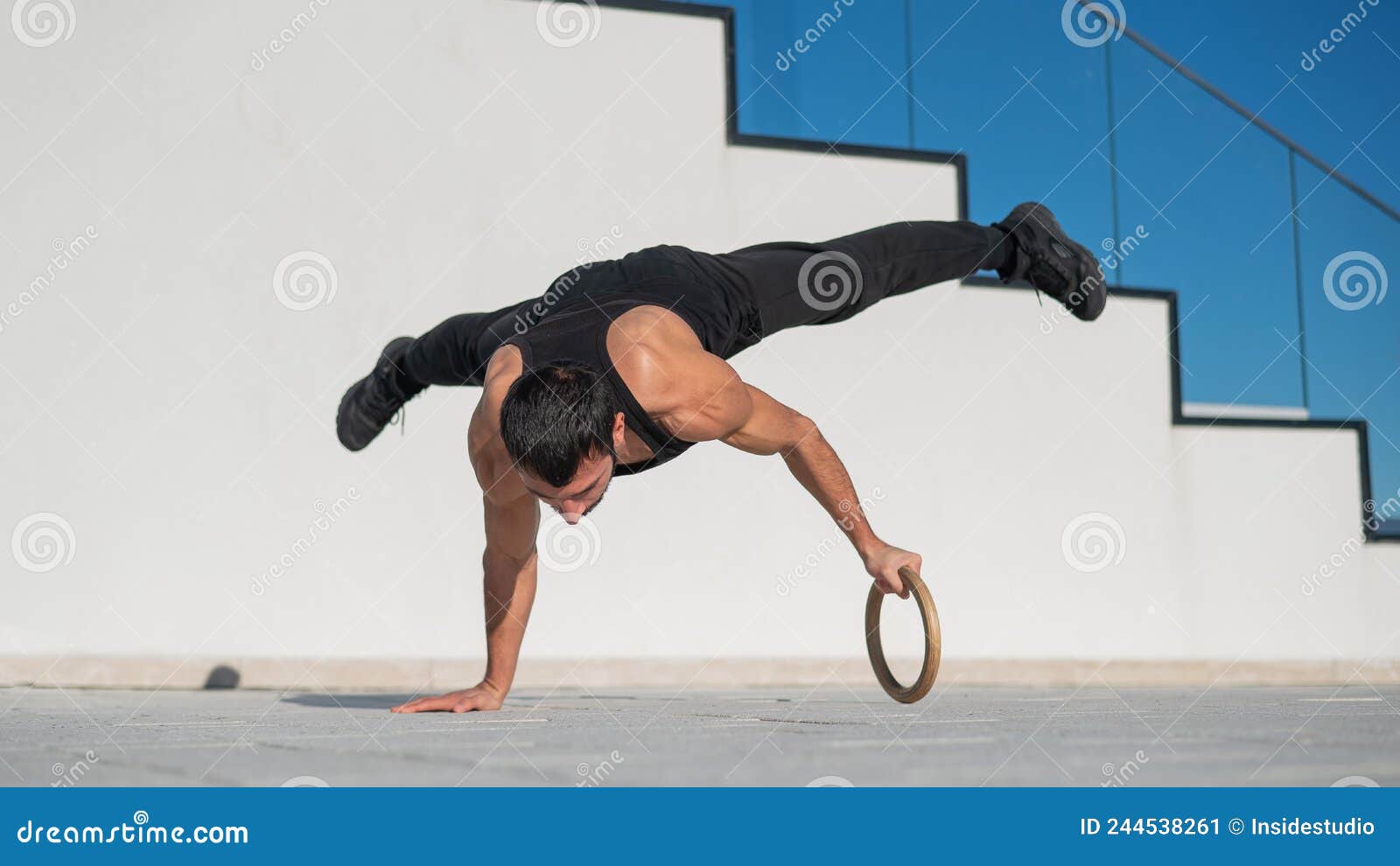 A Man in Black Sportswear Does an Acrobatic Handstand on a Ring ...