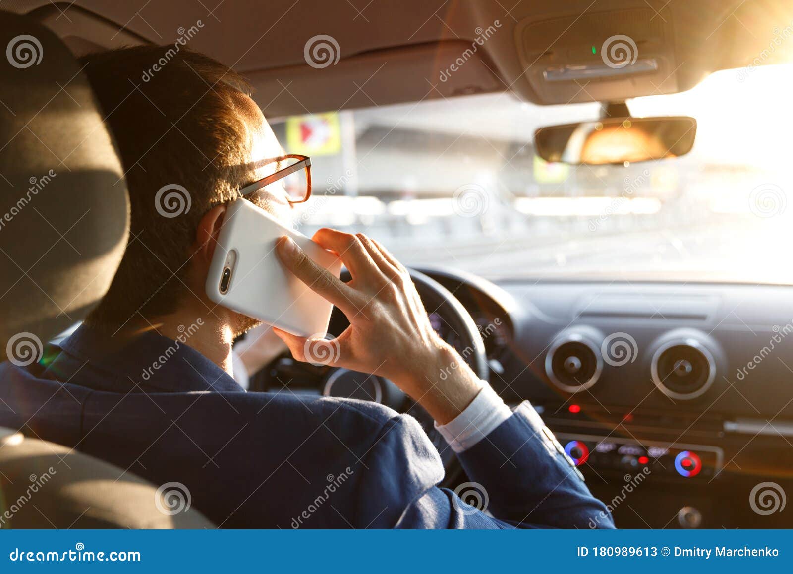 Man in Blazer Using and Talking on Smartphone while Driving a Car at ...