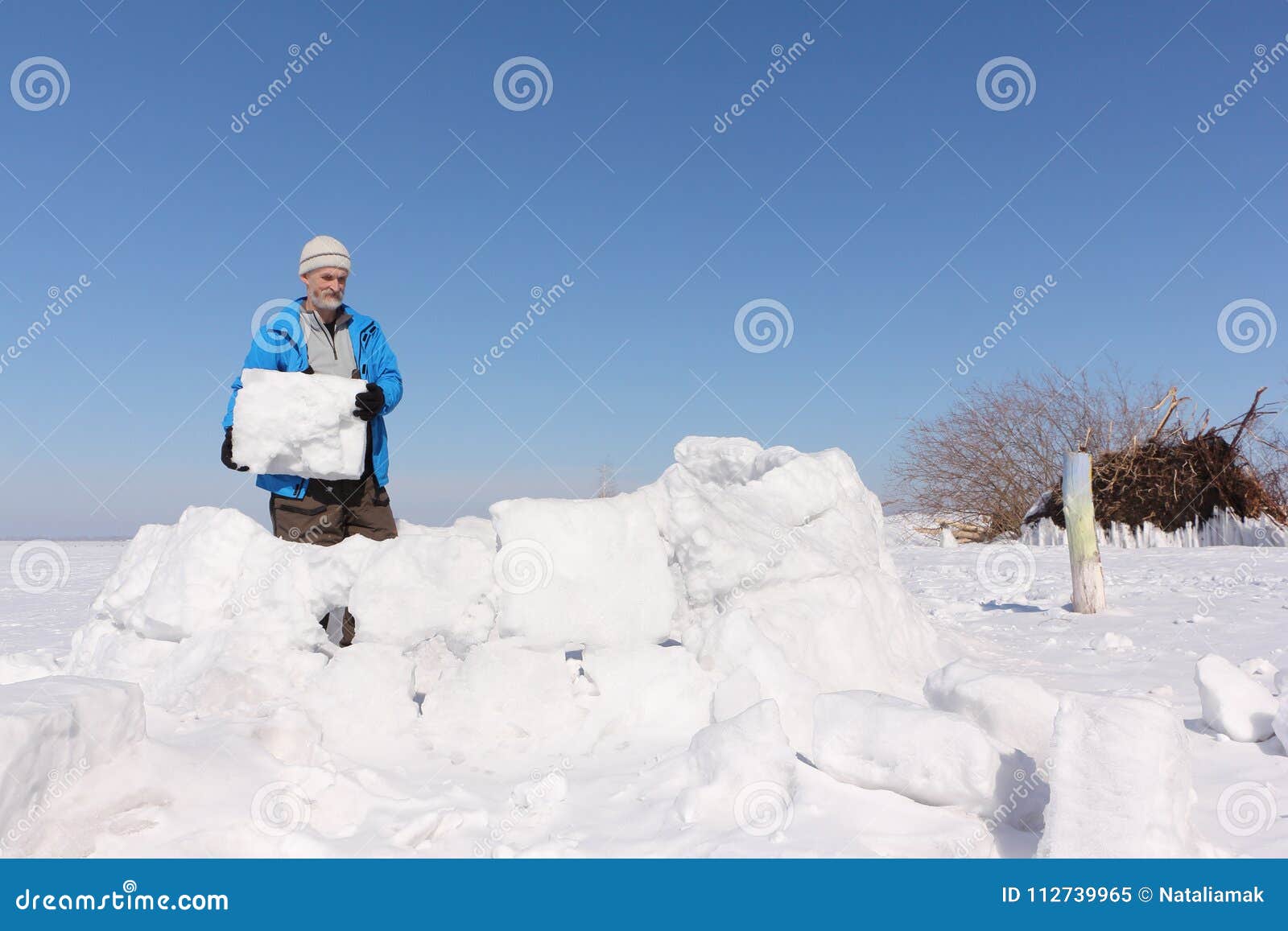 Man in a Blue Jacket Building an Igloo on a Glade Stock Image - Image ...