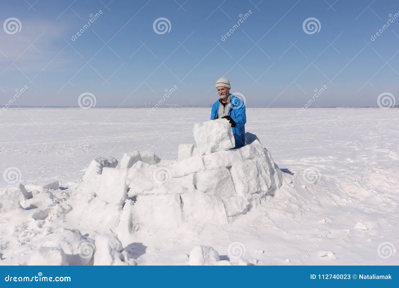Man in a Blue Jacket Building an Igloo on a Glade Stock Image - Image ...