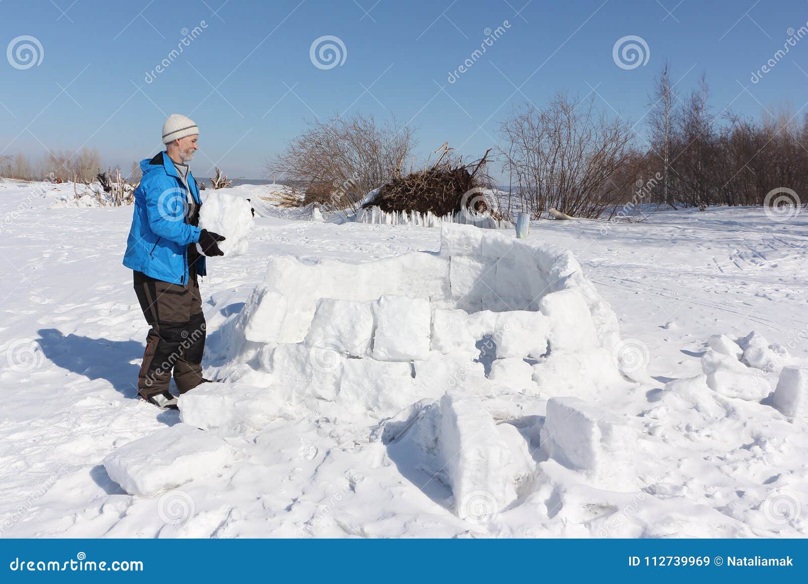 Man in a Blue Jacket Building an Igloo on a Glade Stock Image - Image ...