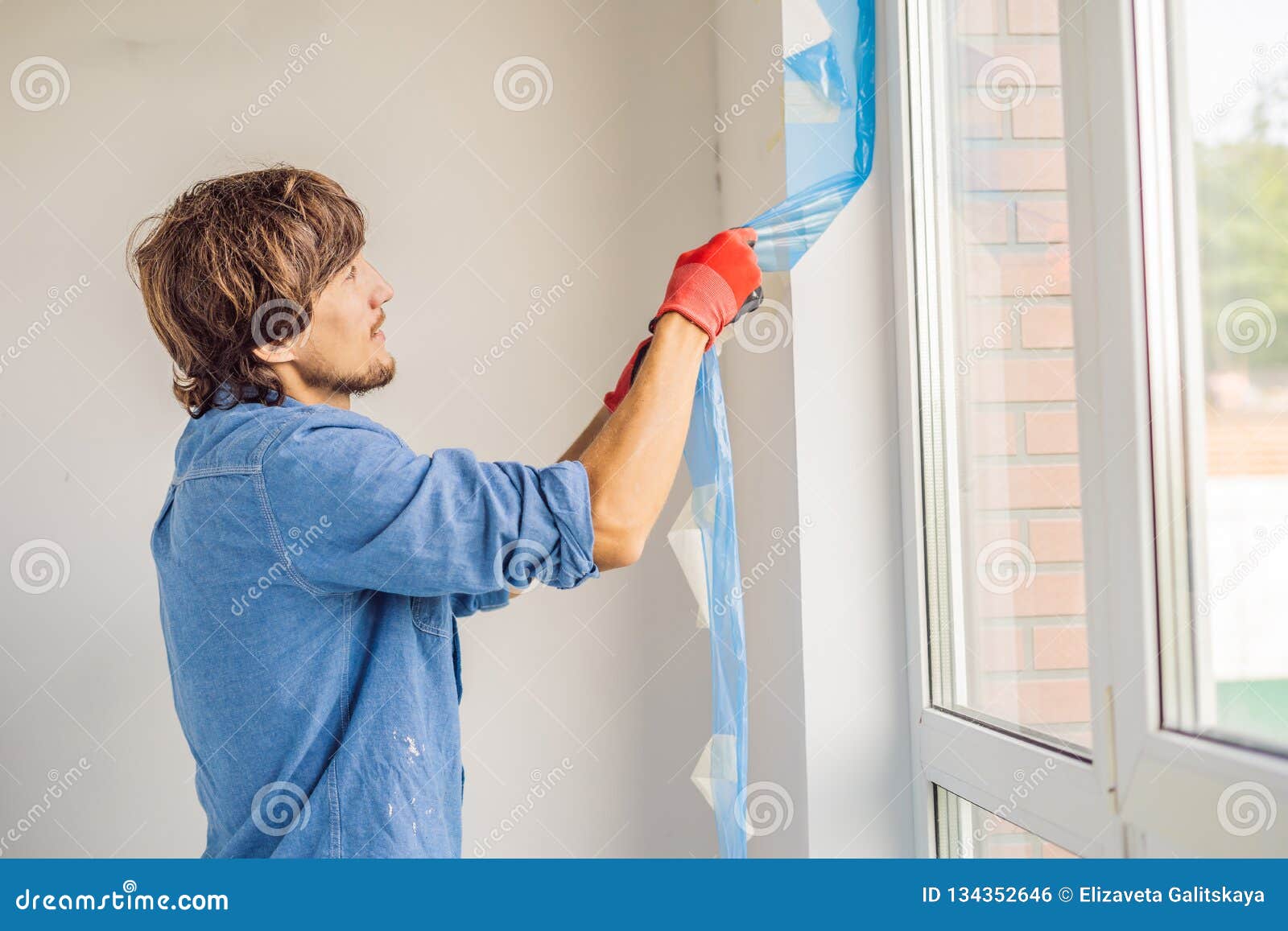 Man in a Blue Shirt Does Window Installation Stock Photo - Image of ...