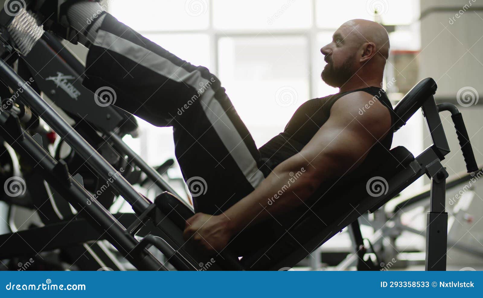 Man Bodybuilder Sideways in the Gym Training on the Machine ...