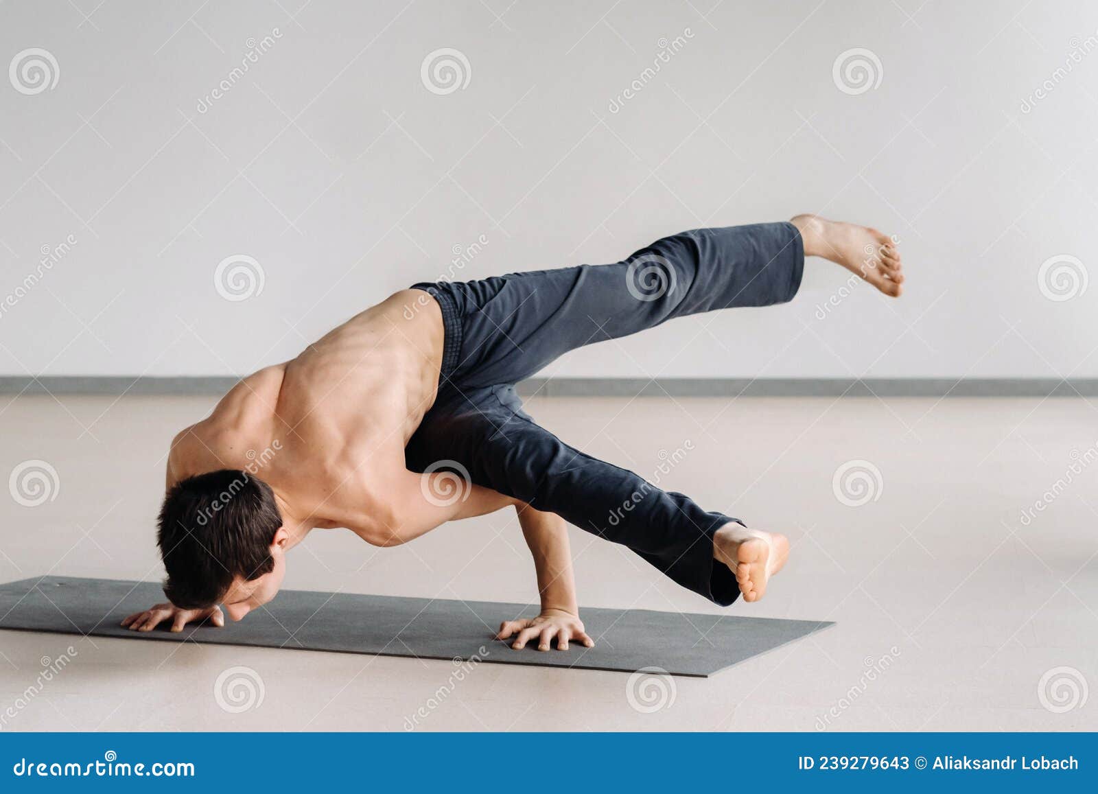 A Man with a Bony Torso Trains Lying Down, Doing a Handstand in the Gym ...