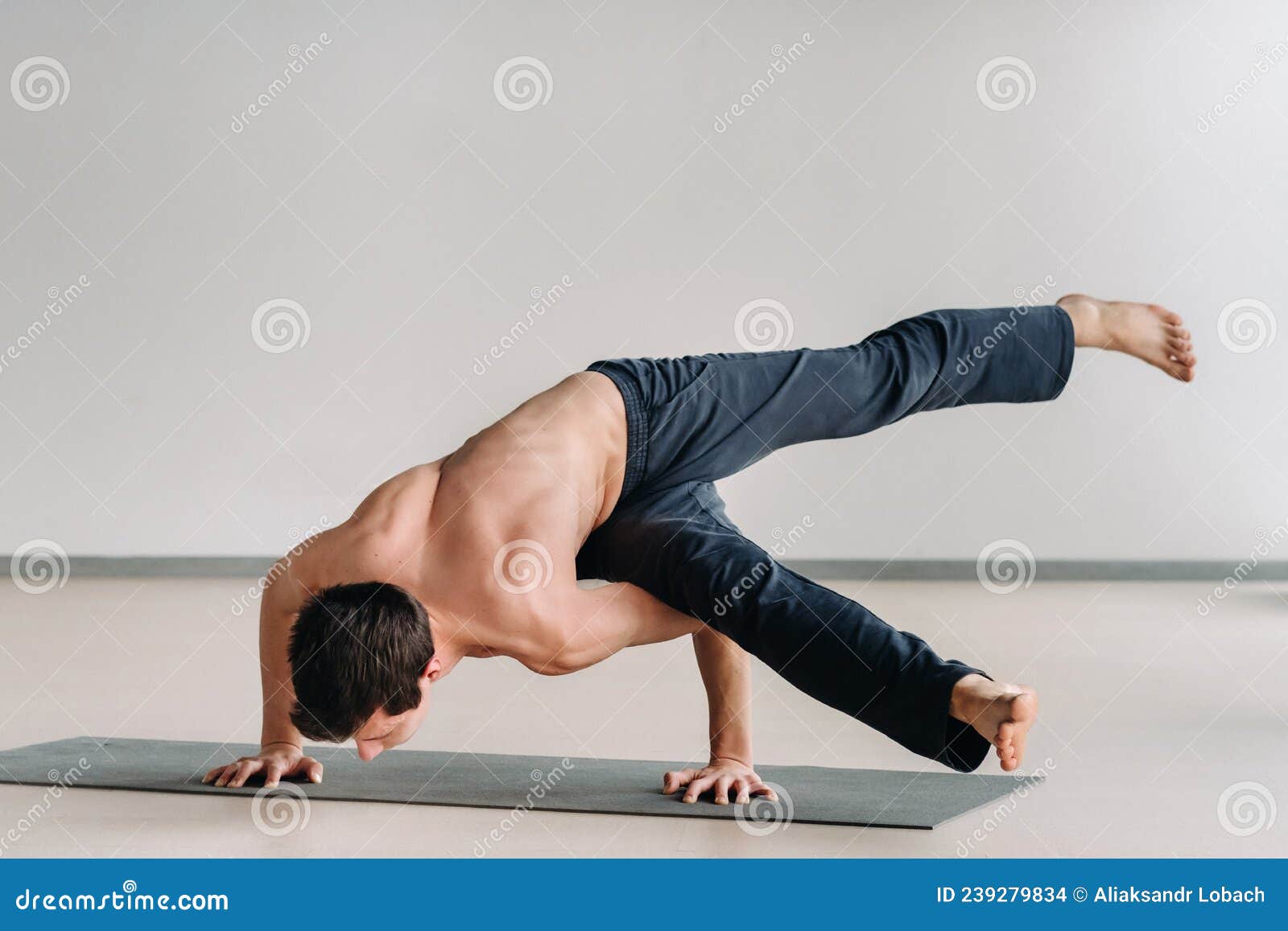 A Man with a Bony Torso Trains Lying Down, Doing a Handstand in the Gym ...