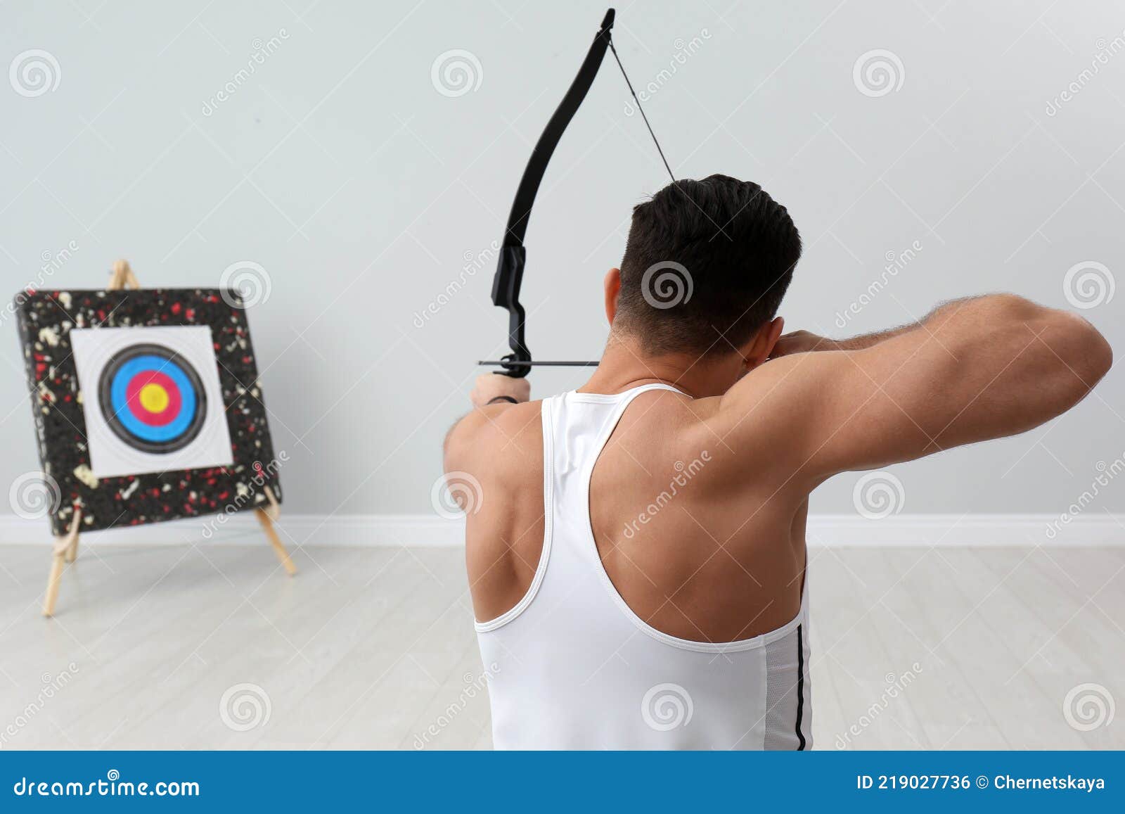 Man with Bow and Arrow Aiming at Archery Target Indoors Stock Photo ... Man with Bow and Arrow Aiming at Archery Target Indoors Stock Photo ...