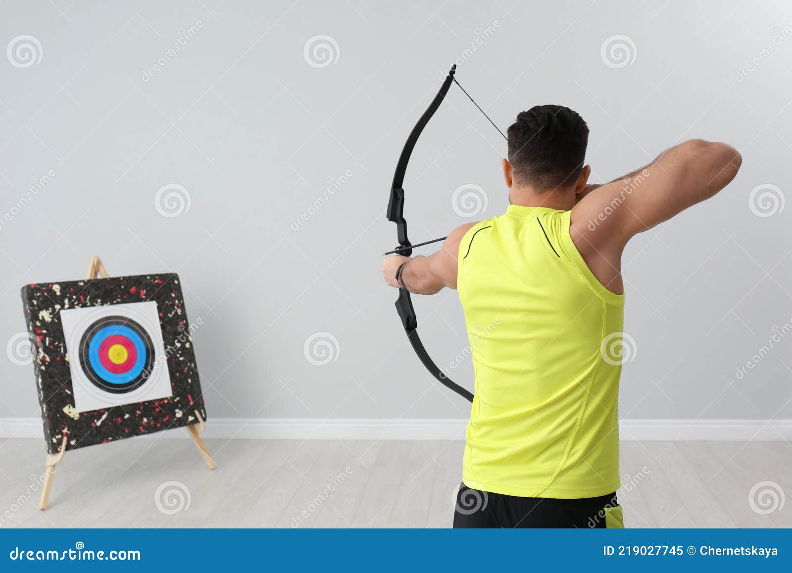 Man with Bow and Arrow Aiming at Archery Target Indoors Stock Image ... Man with Bow and Arrow Aiming at Archery Target Indoors Stock Image ...