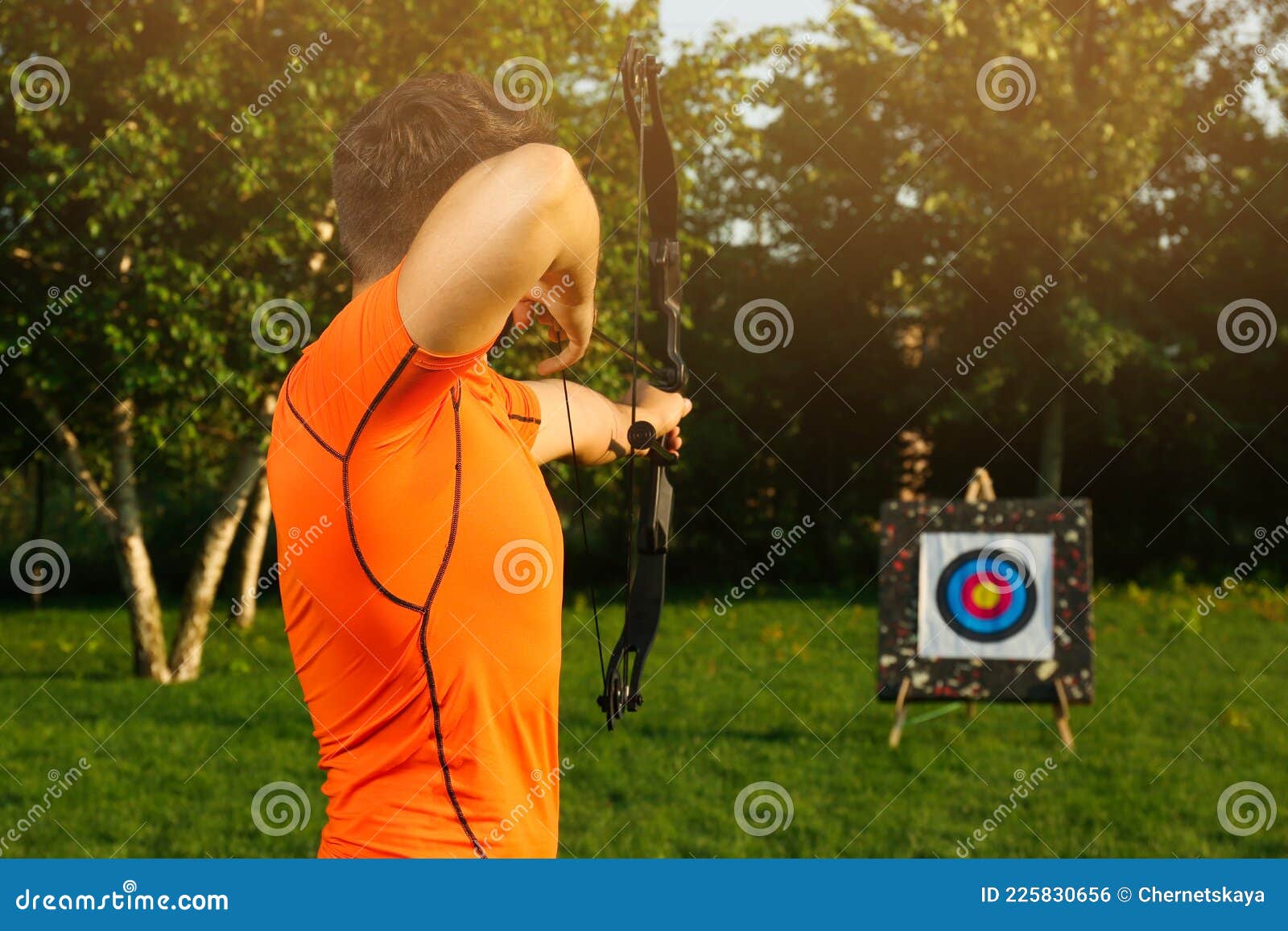 Man with Bow and Arrow Aiming at Archery Target in Park Stock Photo ...