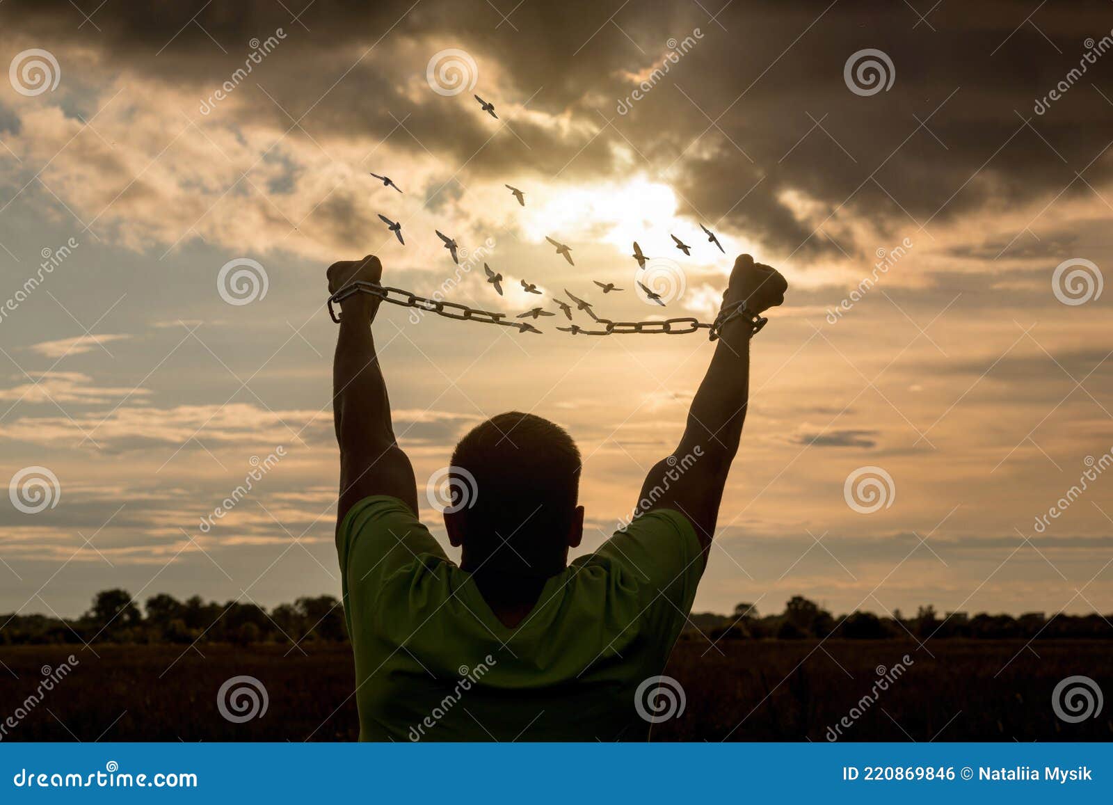 A Man Breaks the Chain that Crumbles into Birds Against the Backdrop of ...