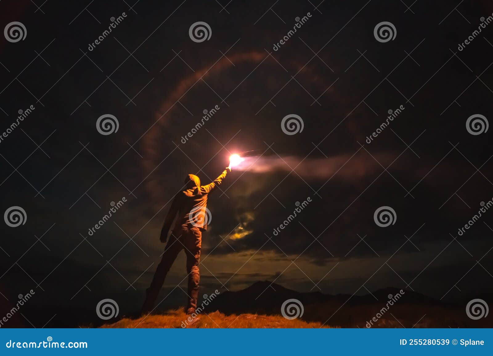 The Man with a Bright Firework Stick Standing on a Mountain. Evening ...