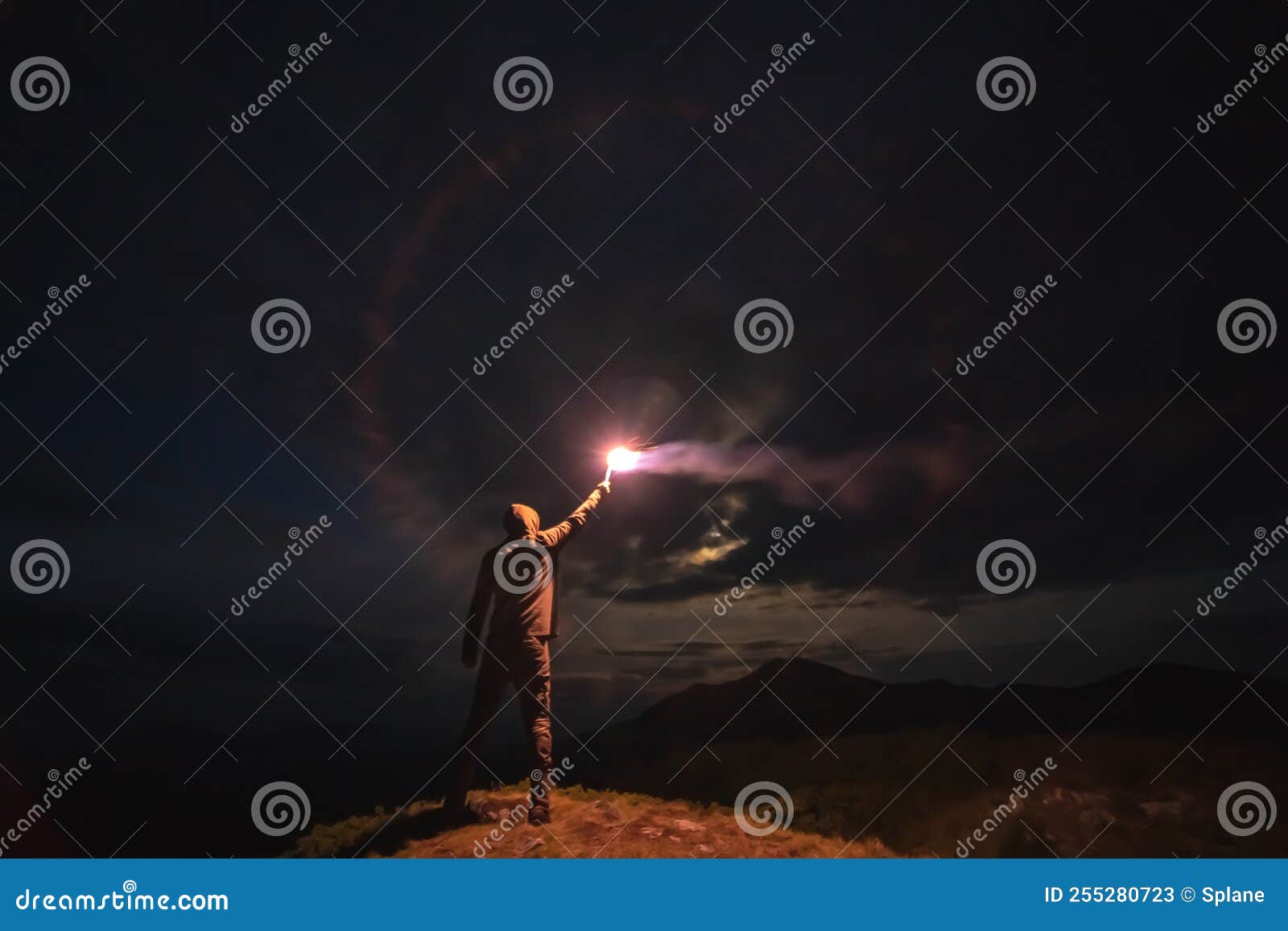 The Man with a Bright Firework Stick Standing on a Mountain. Evening ...