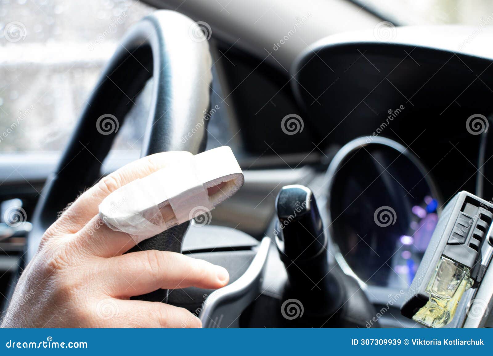 A Man with a Broken Finger Holds the Steering Wheel of a Car Stock ...