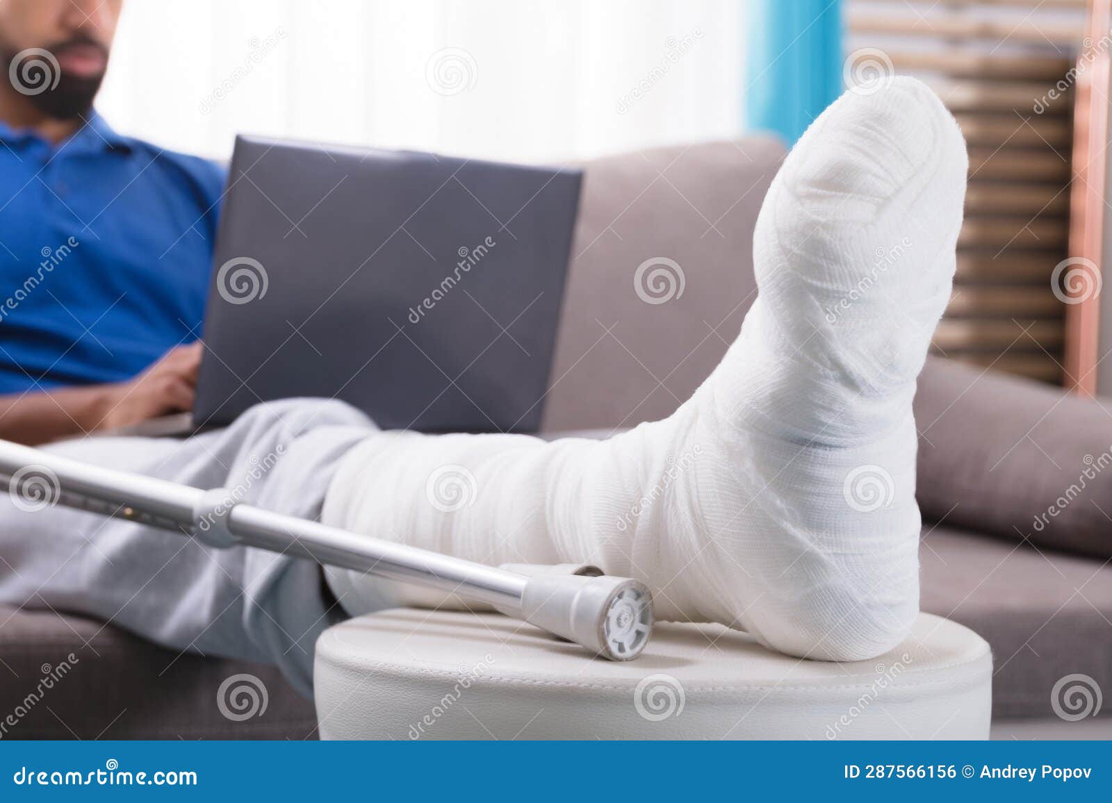 Man with Broken Leg Using Laptop Stock Photo - Image of crutch, home ...