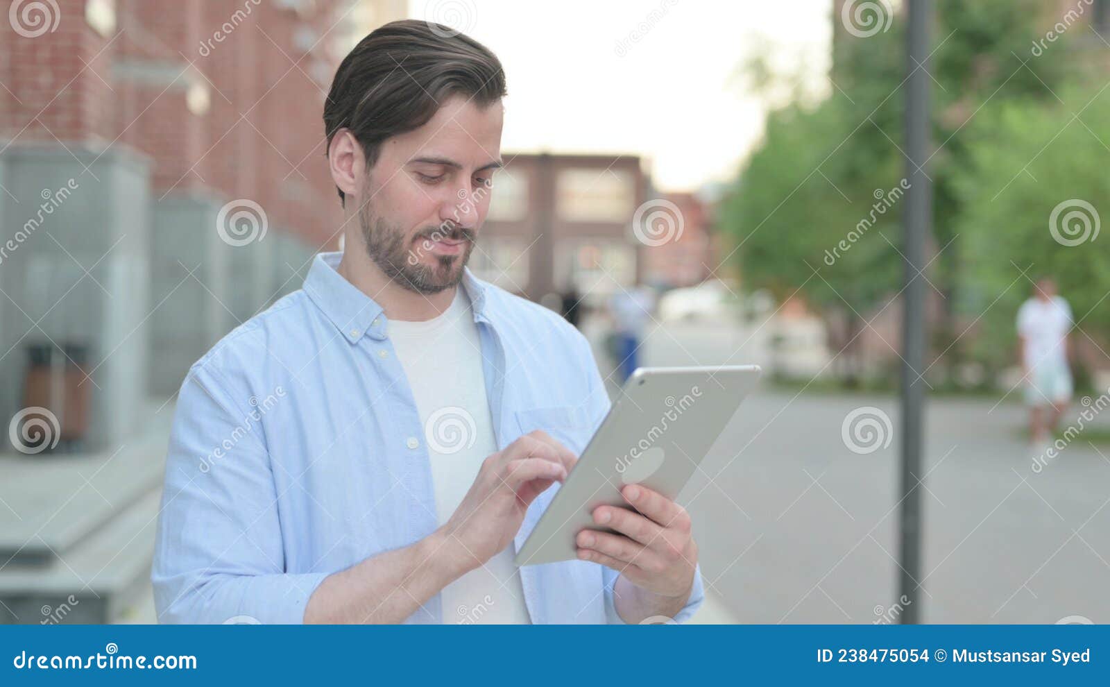 Man Browing Internet on Tablet while Standing Outdoor Stock Photo ...