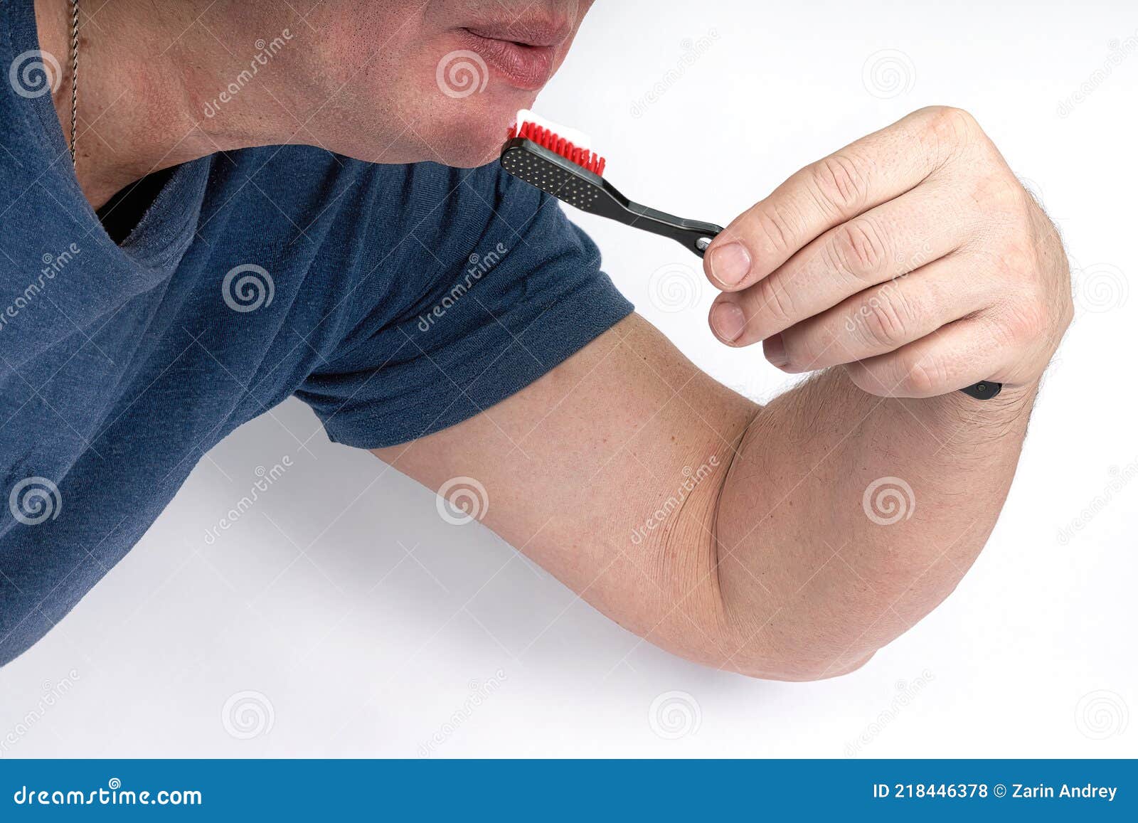 A Man Brushes His Teeth with a Black Toothbrush with a Red Shield Stock ...