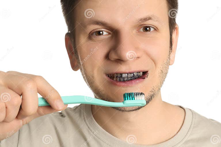 Man Brushing Teeth with Charcoal Toothpaste on White Background ...