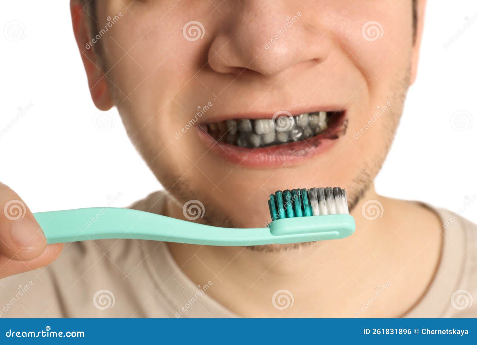 Man Brushing Teeth With Charcoal Toothpaste On White Background