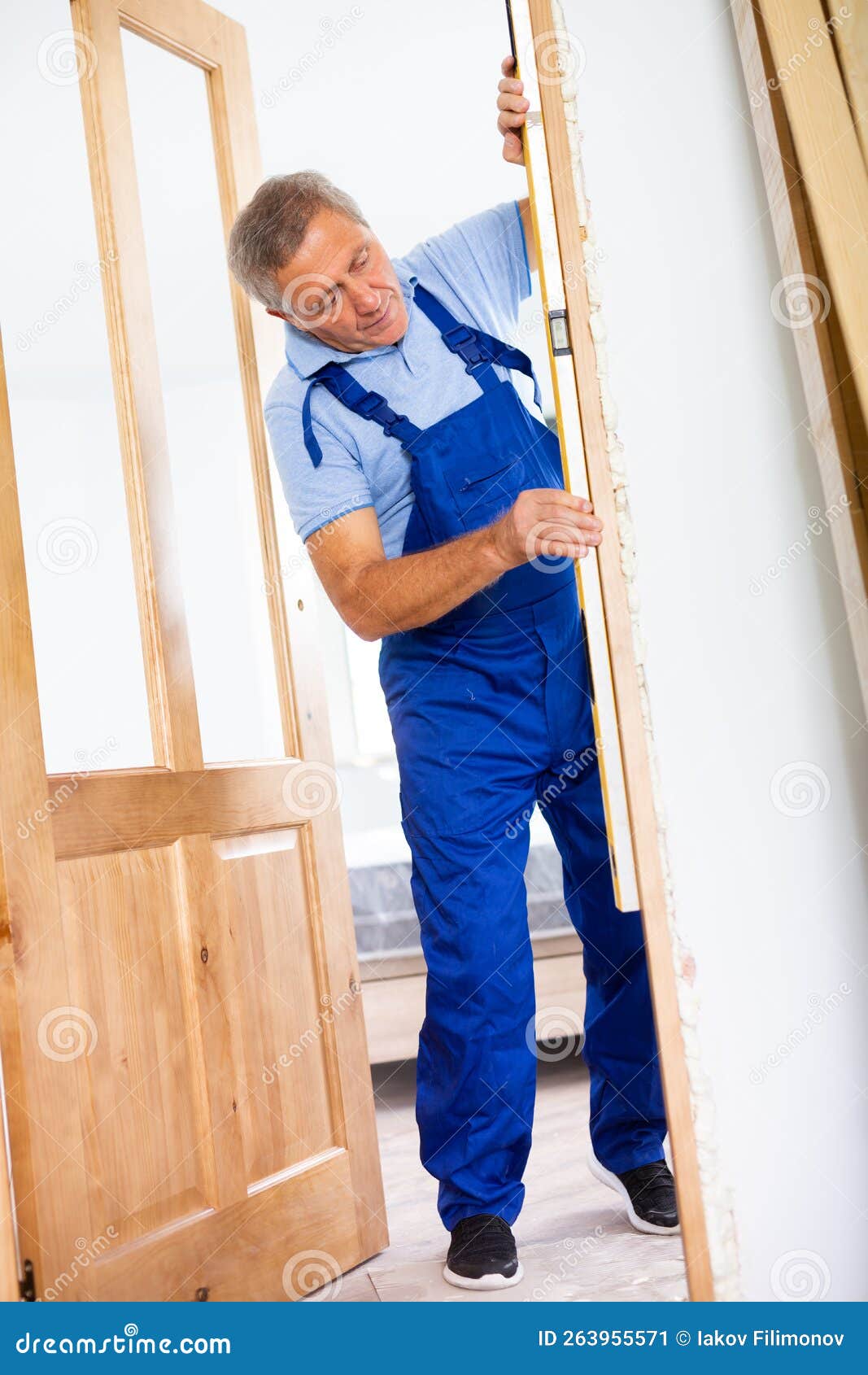 Man Builder in Blue Overalls Measures Deviations from a Given Vertical ...
