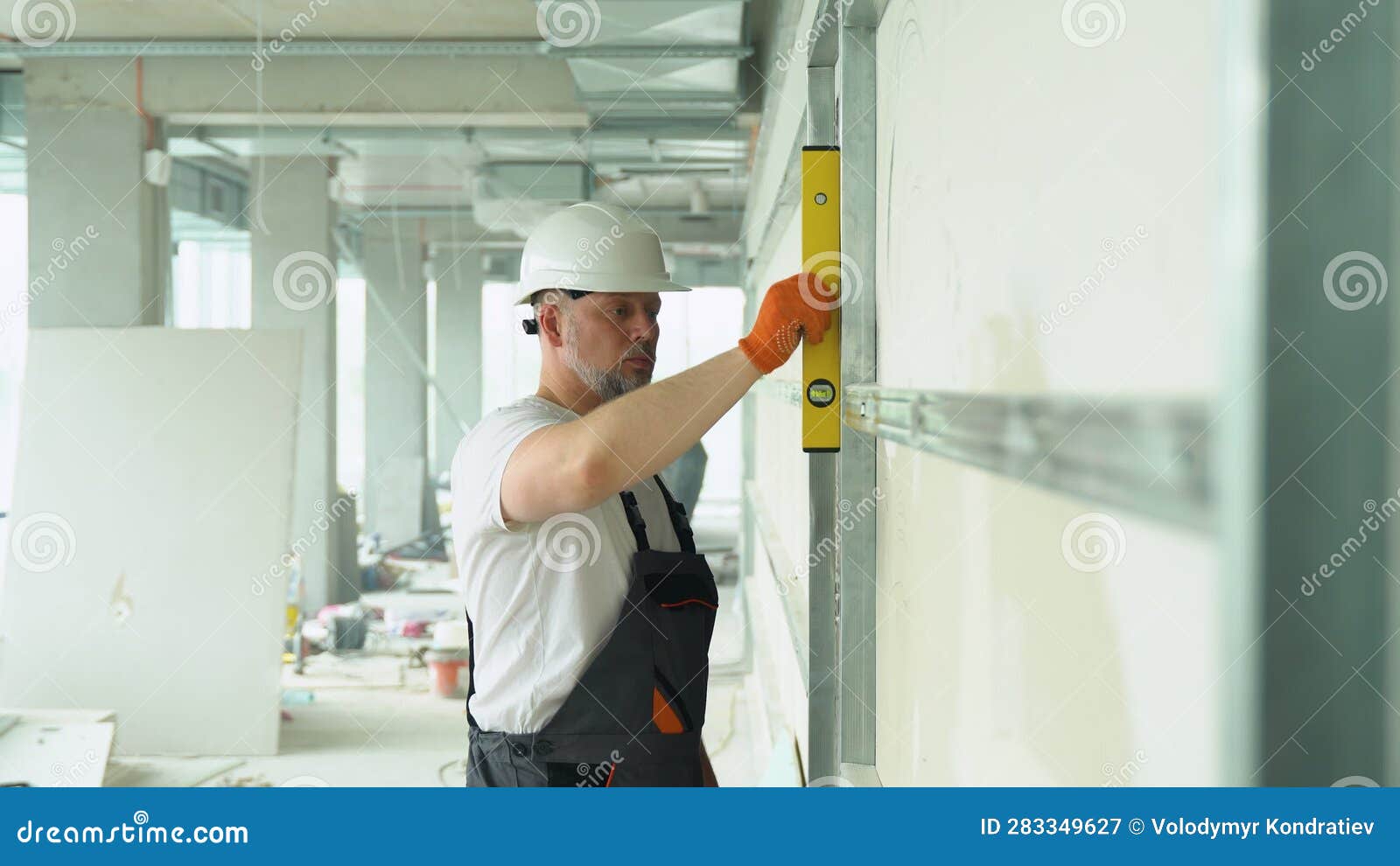 A Man Builder Measures of the Vertical Deviation of Plasterboard Wall ...