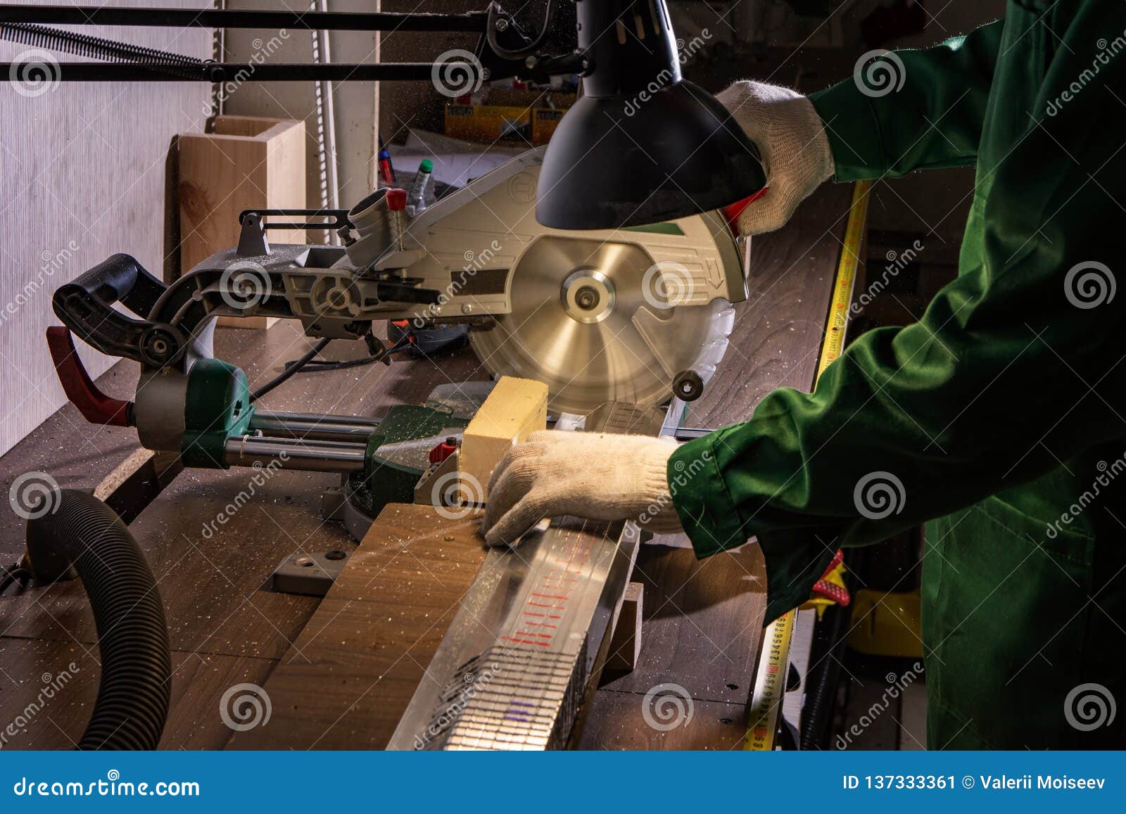 A Man Builder Saws a Board with a Circular Saw in the Workshop Stock ...