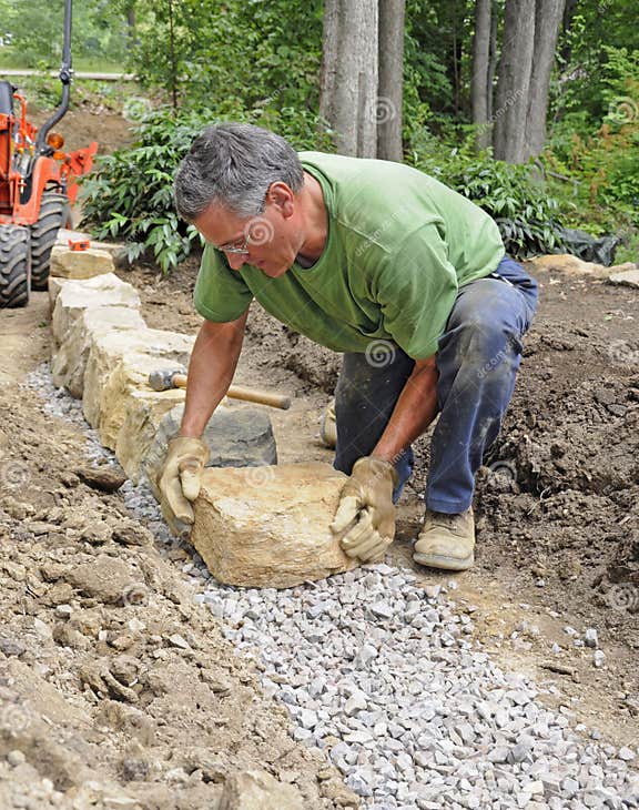 Man building stone wall stock image. Image of garden - 17735239