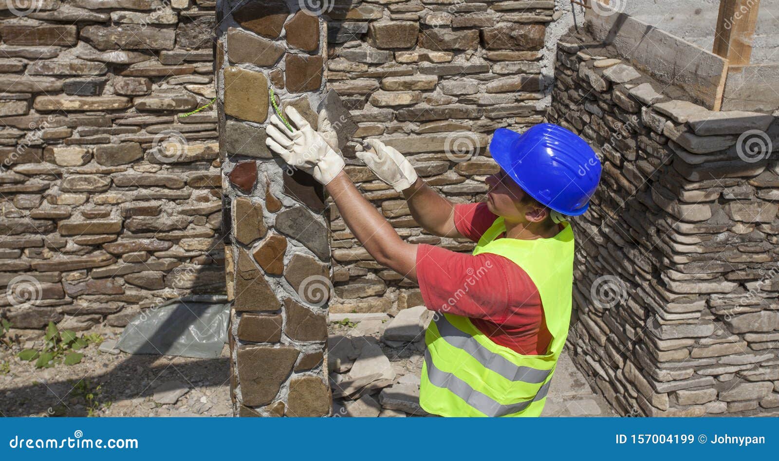 Man building stone wall stock image. Image of industry - 157004199