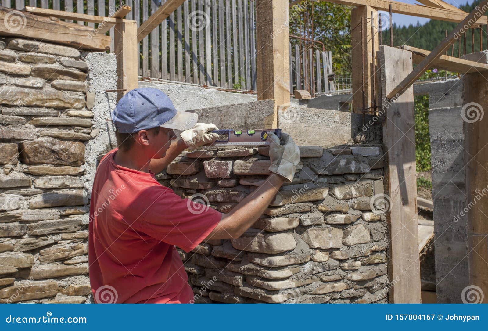 Man building stone wall stock image. Image of builder - 157004167