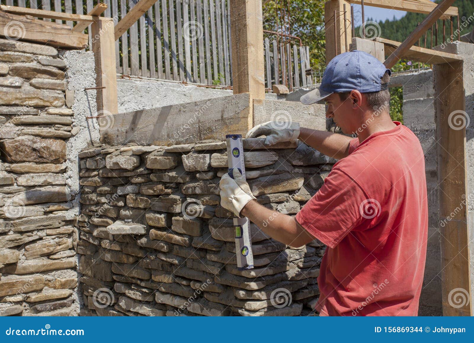 Man building stone wall stock photo. Image of house - 156869344