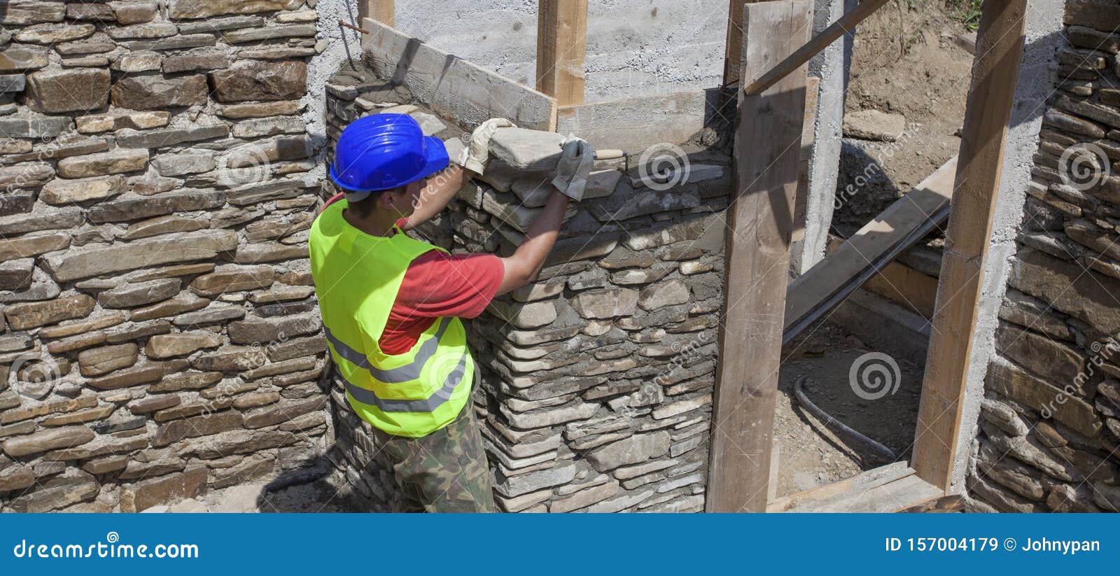 Man building stone wall stock image. Image of concrete - 157004179